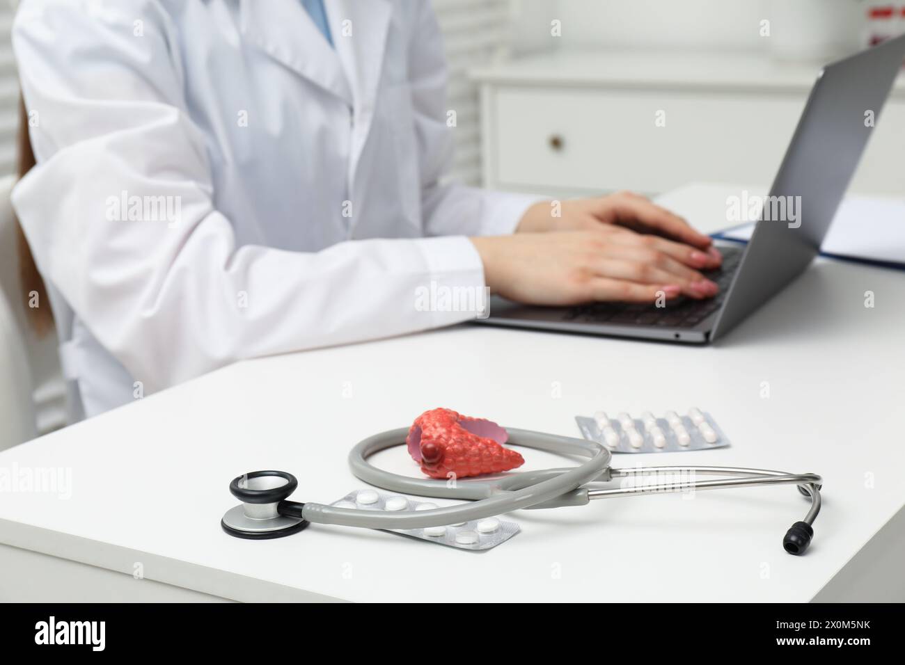 Endocrinologist working at table, focus on stethoscope and model of ...