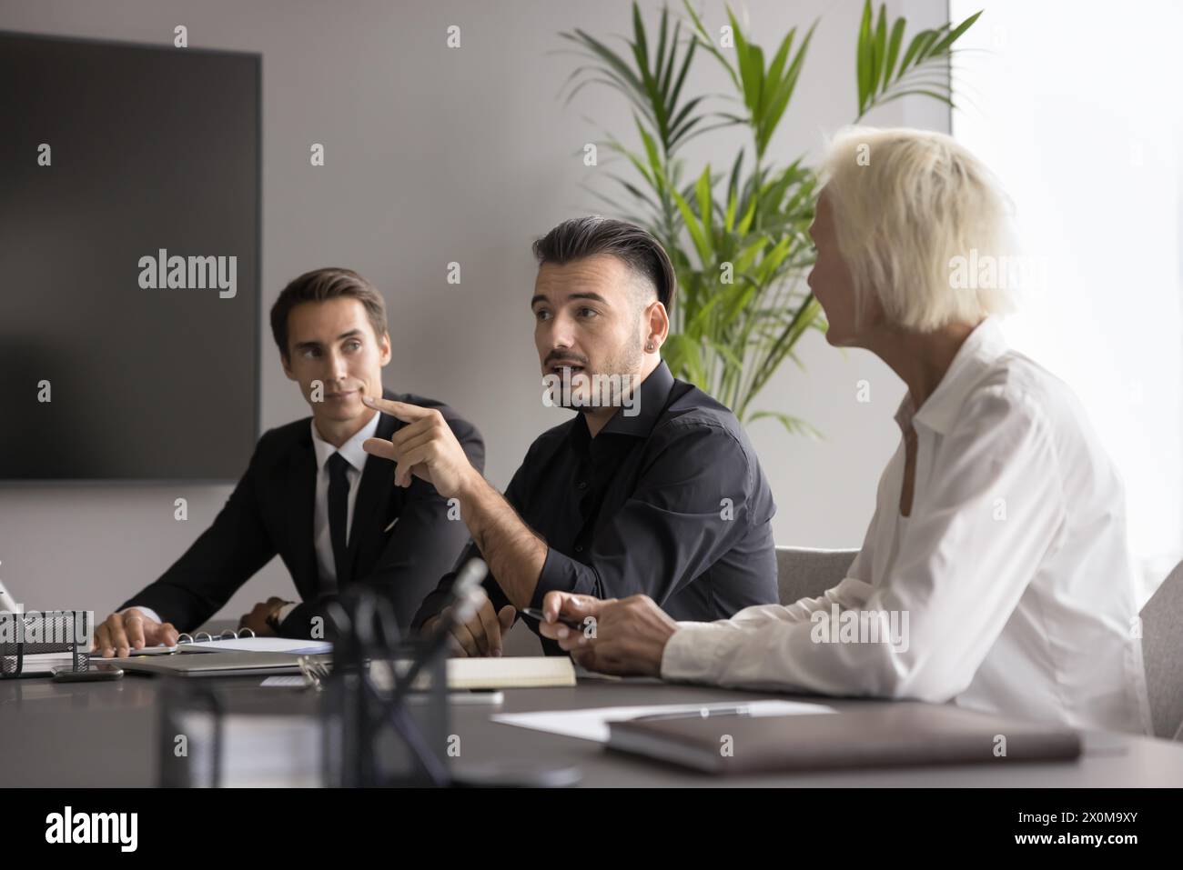 Young male team leader explaining project details to employees Stock ...