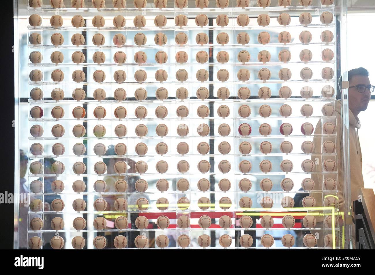 A customer walks past a baseball display on the first day of operation ...