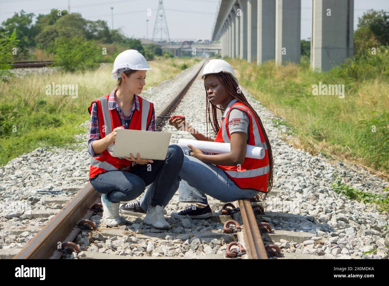 Two engineer with safety helmet and high-visibility vest reviewing work ...