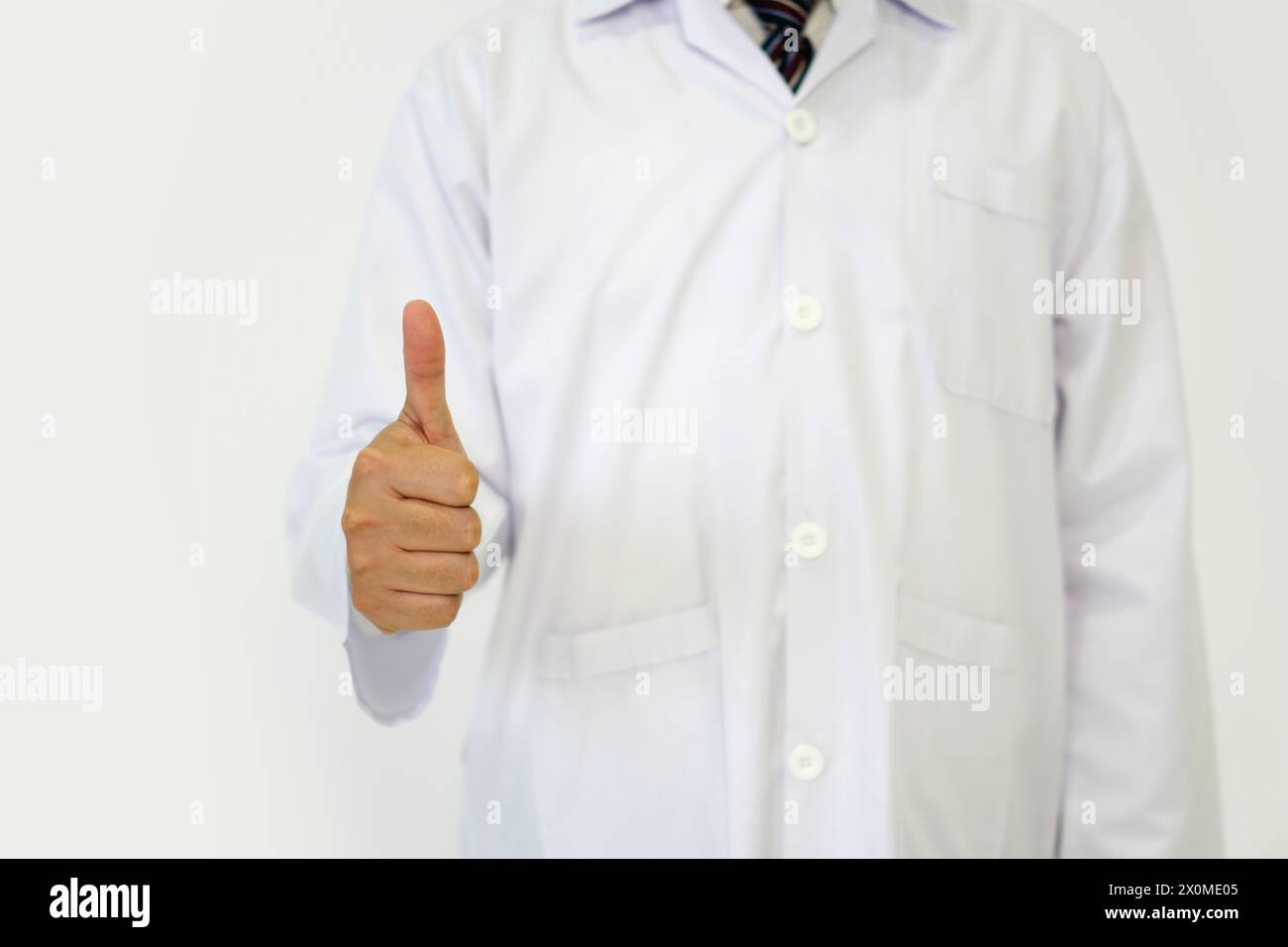 Doctor or scientist in a white lab coat standing with finger thumbs up ...