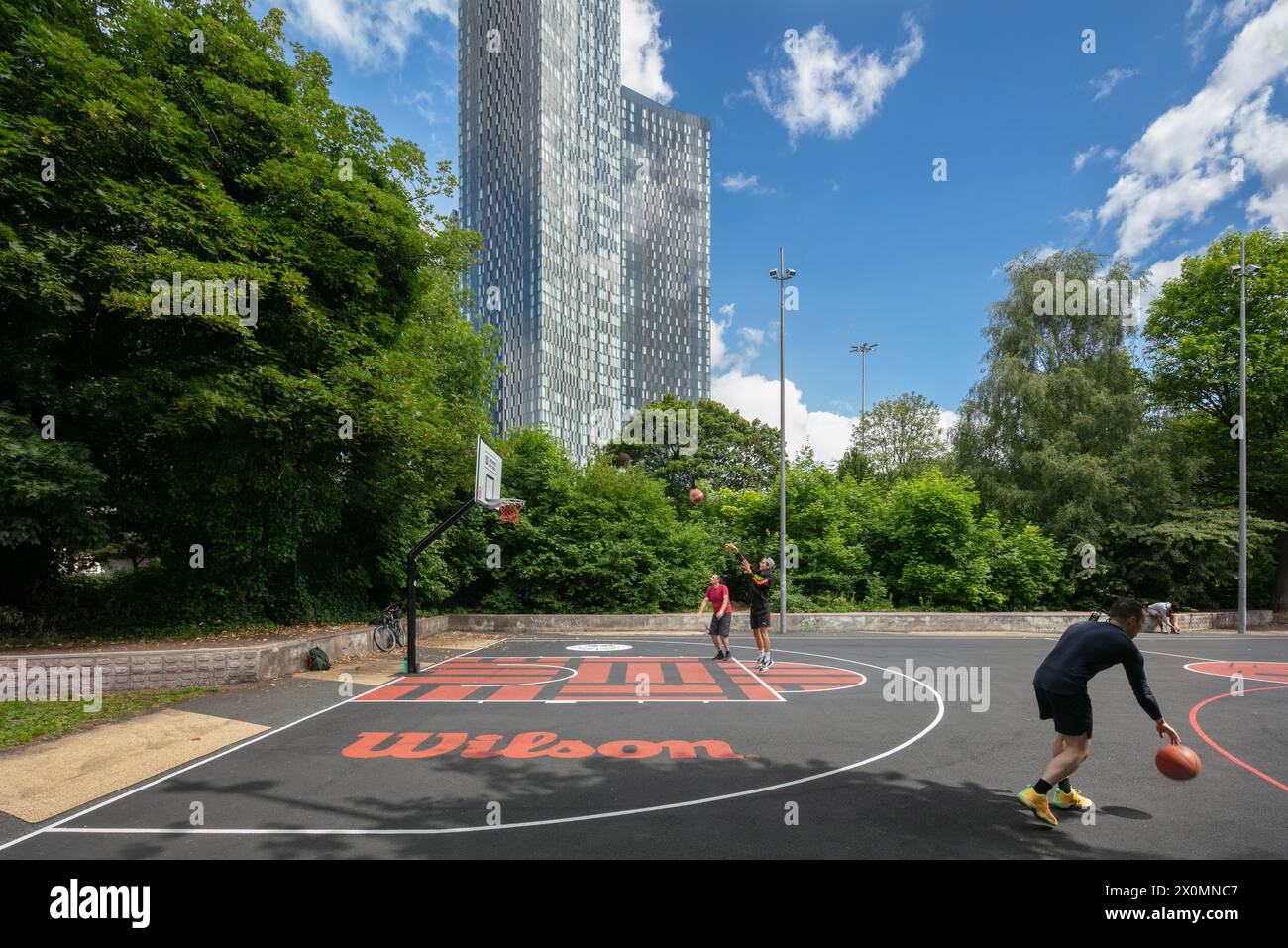 People playing basketball at the Hulme Park basketball court in ...