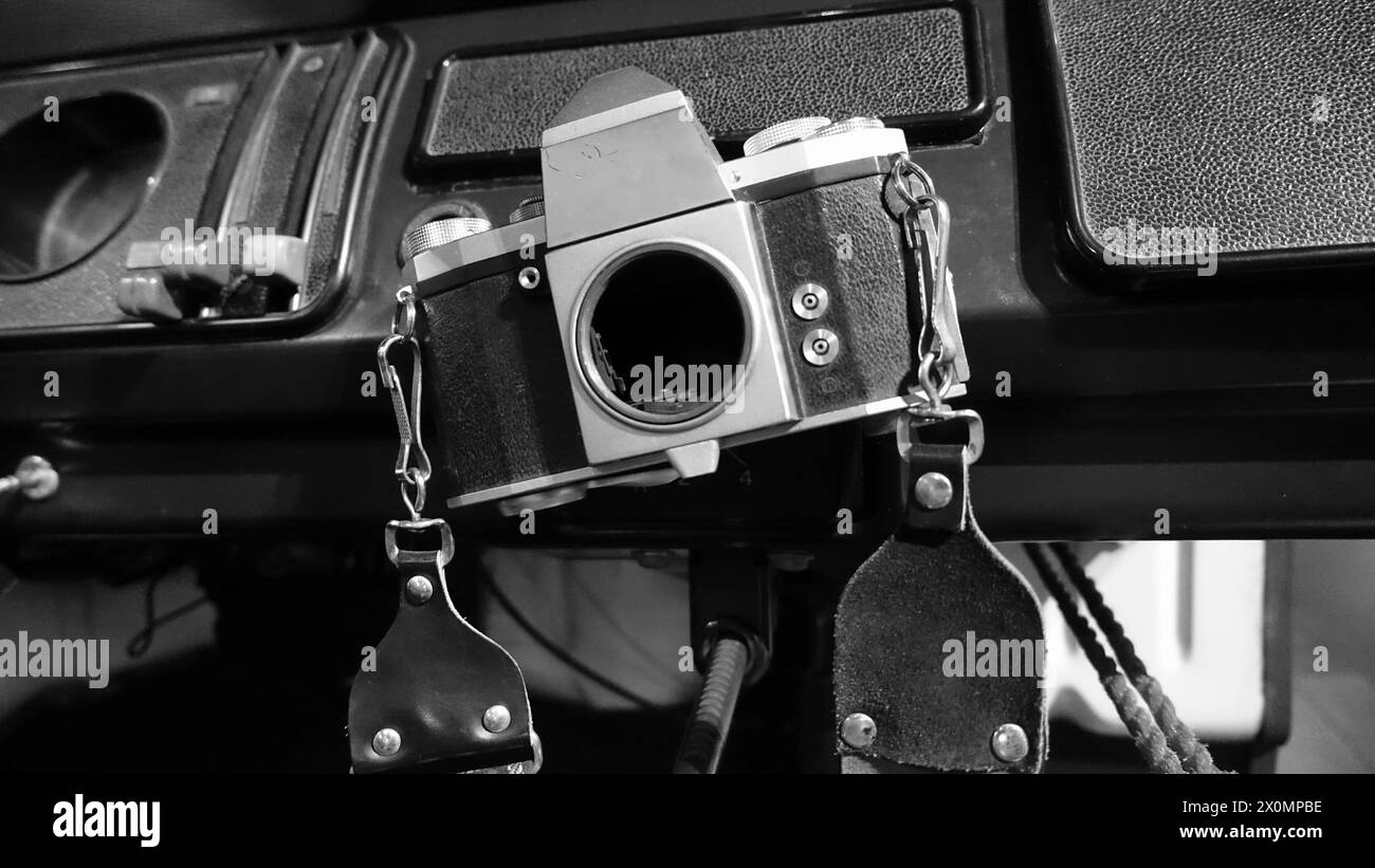 Black and white photo of an antique camera hanging from an old vehicle ...