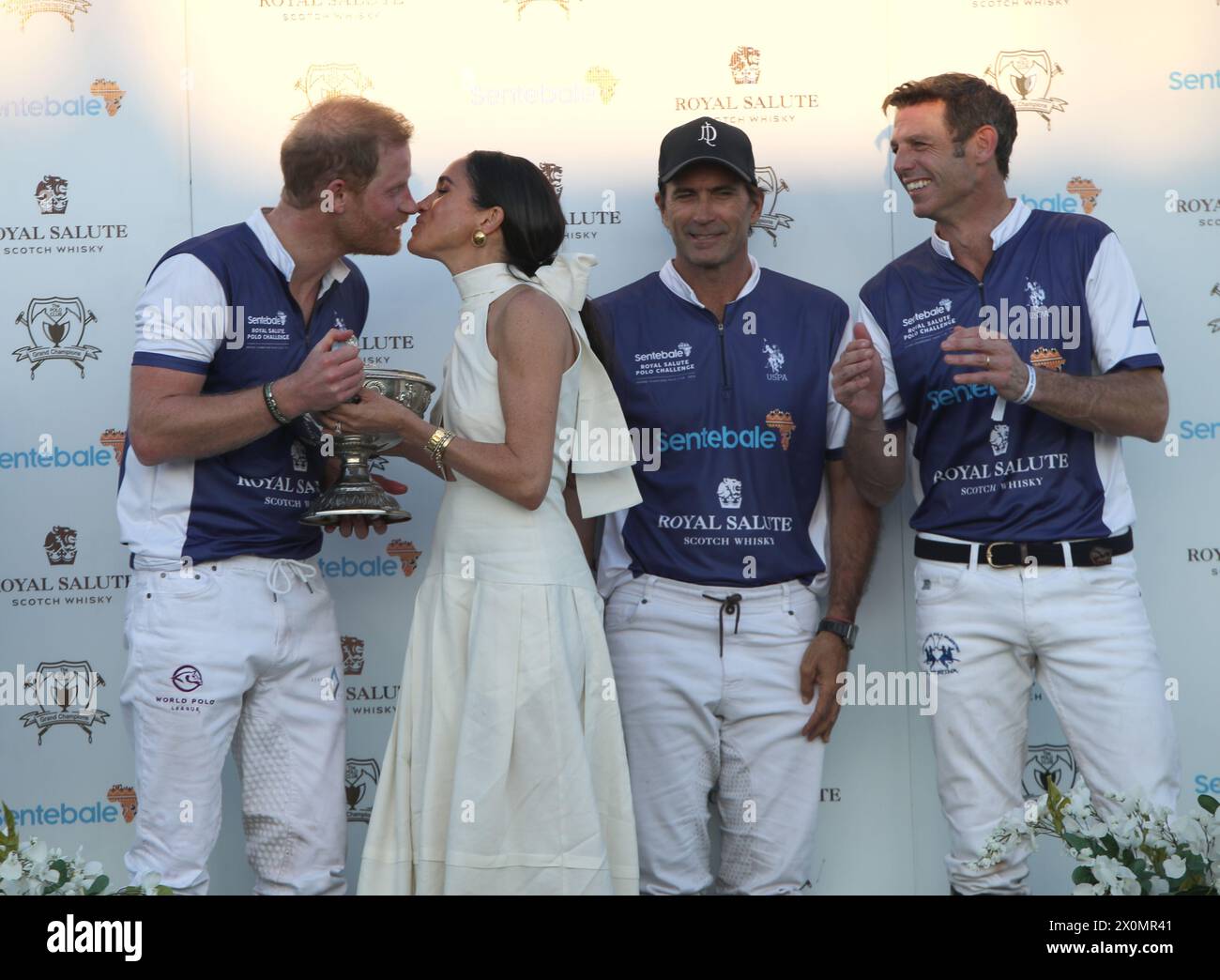 The Duchess of Sussex presents the trophy to her husband, the Duke of ...