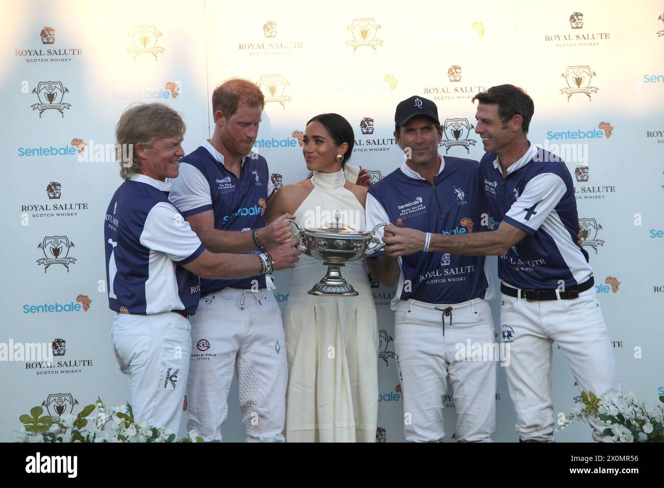 The Duchess of Sussex presents the trophy to her husband, the Duke of ...