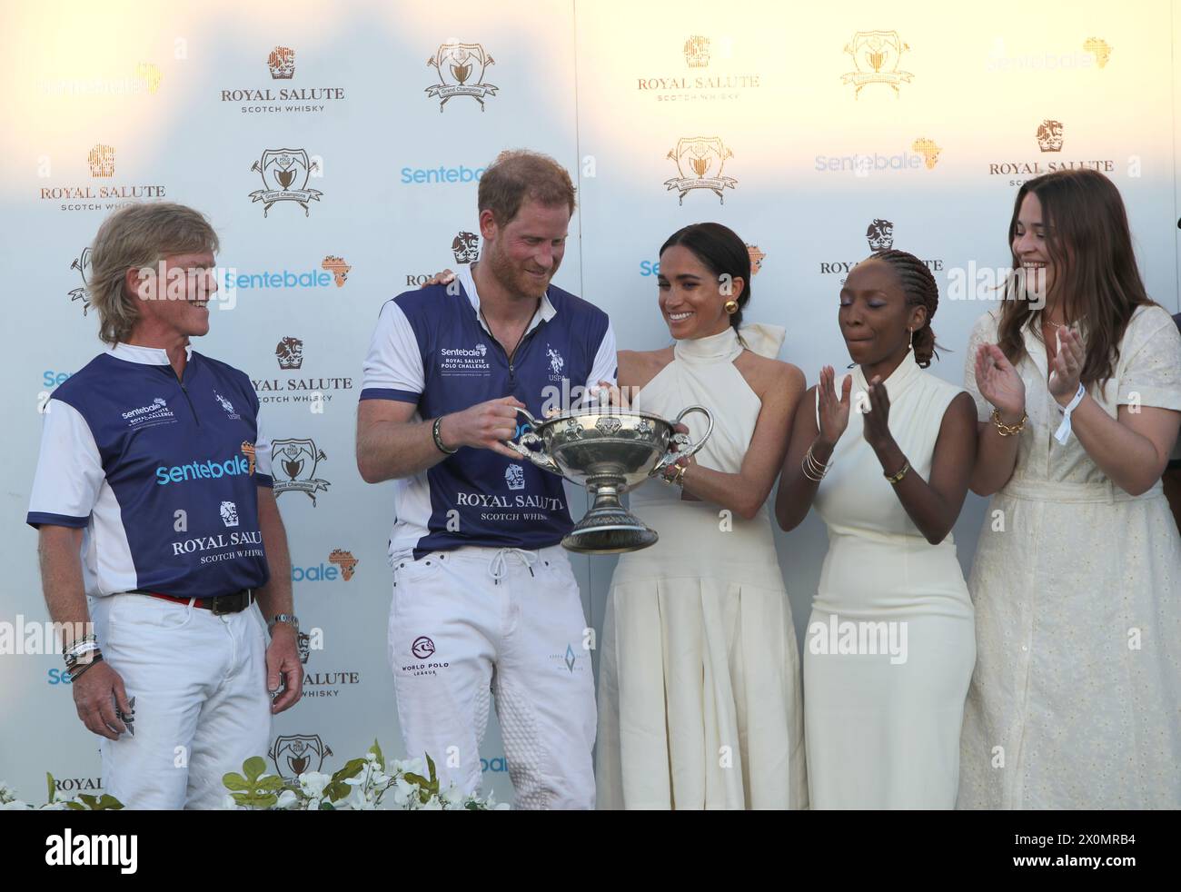 The Duchess of Sussex presents the trophy to her husband, the Duke of ...