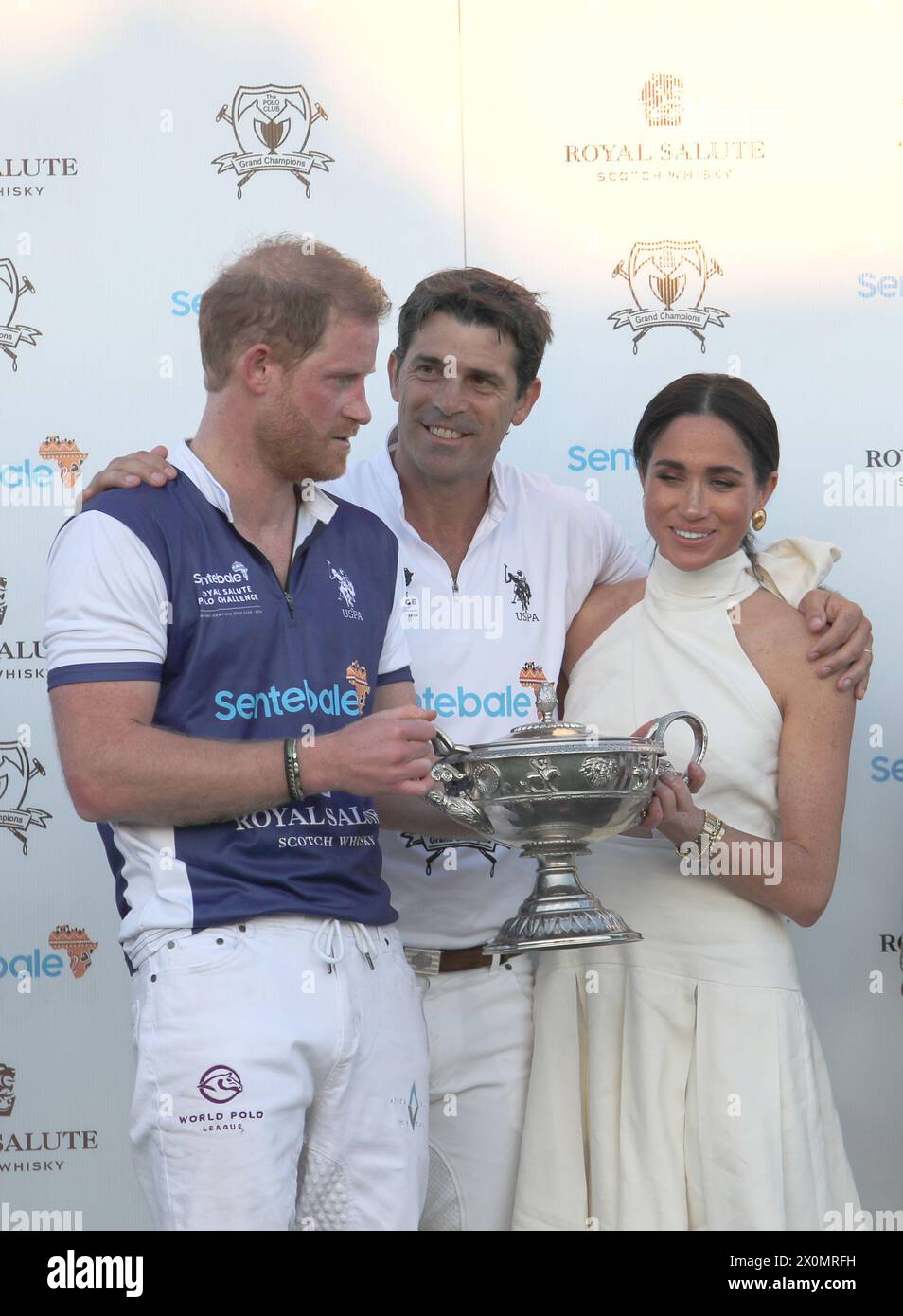 The Duchess of Sussex presents the trophy to her husband, the Duke of ...