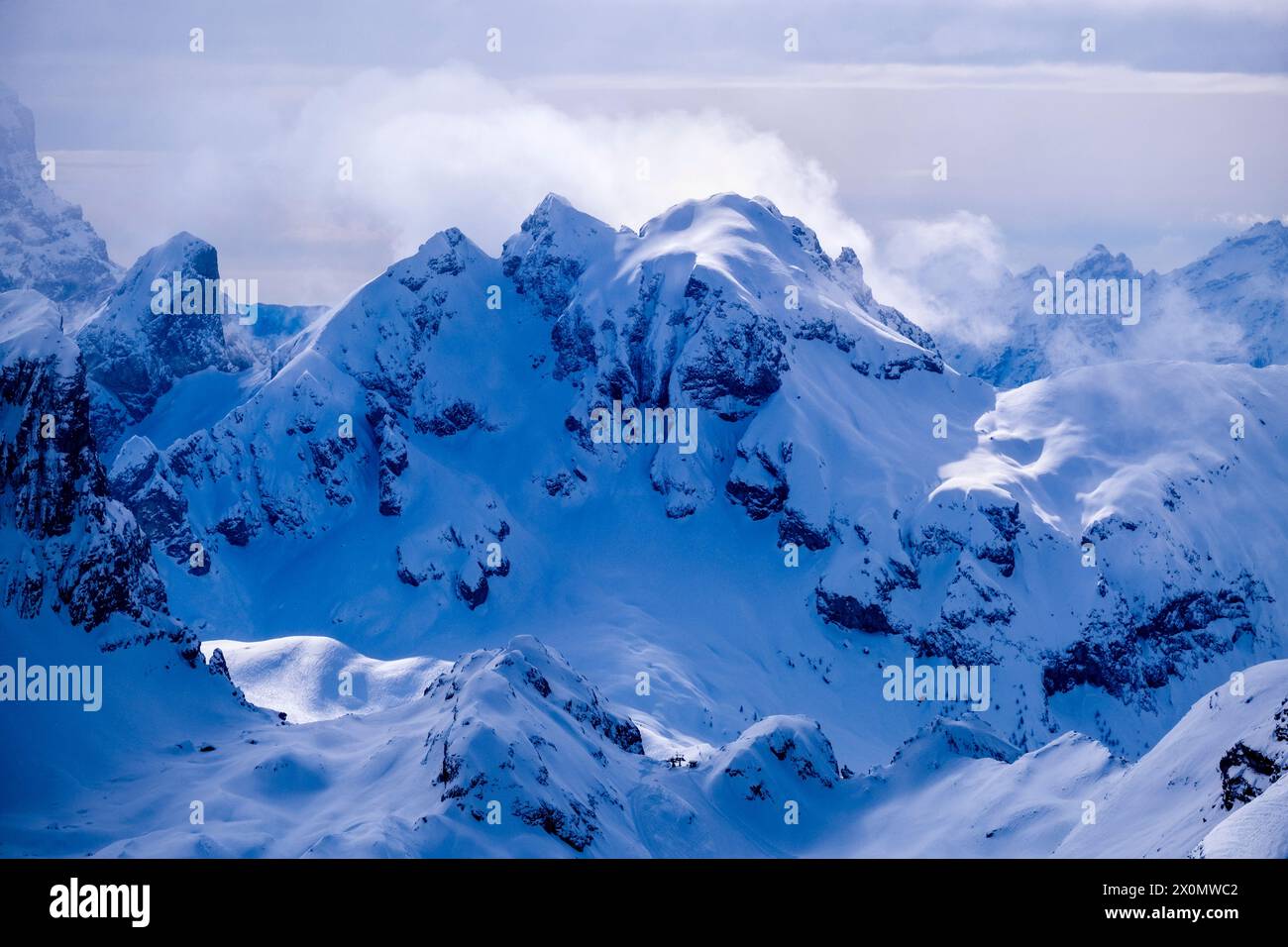 The snow-covered summit of Monte Cernera, surrounded by alpine Dolomite ...
