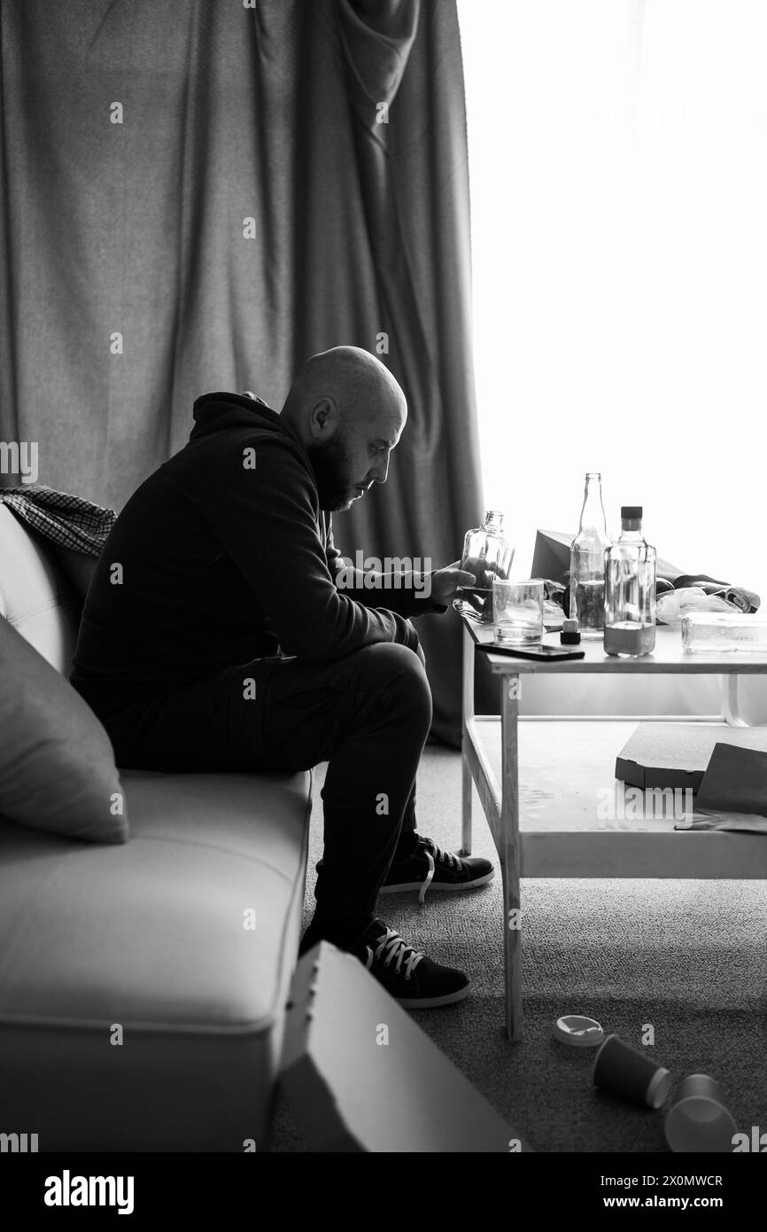 drunk man at home on couch holding whiskey glass, having alcoholism ...