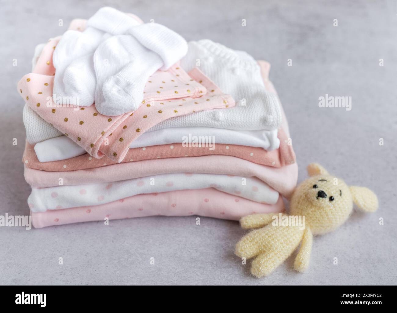 Stack of Baby bodysuits on a grey background. Baby crocketed toy of ...