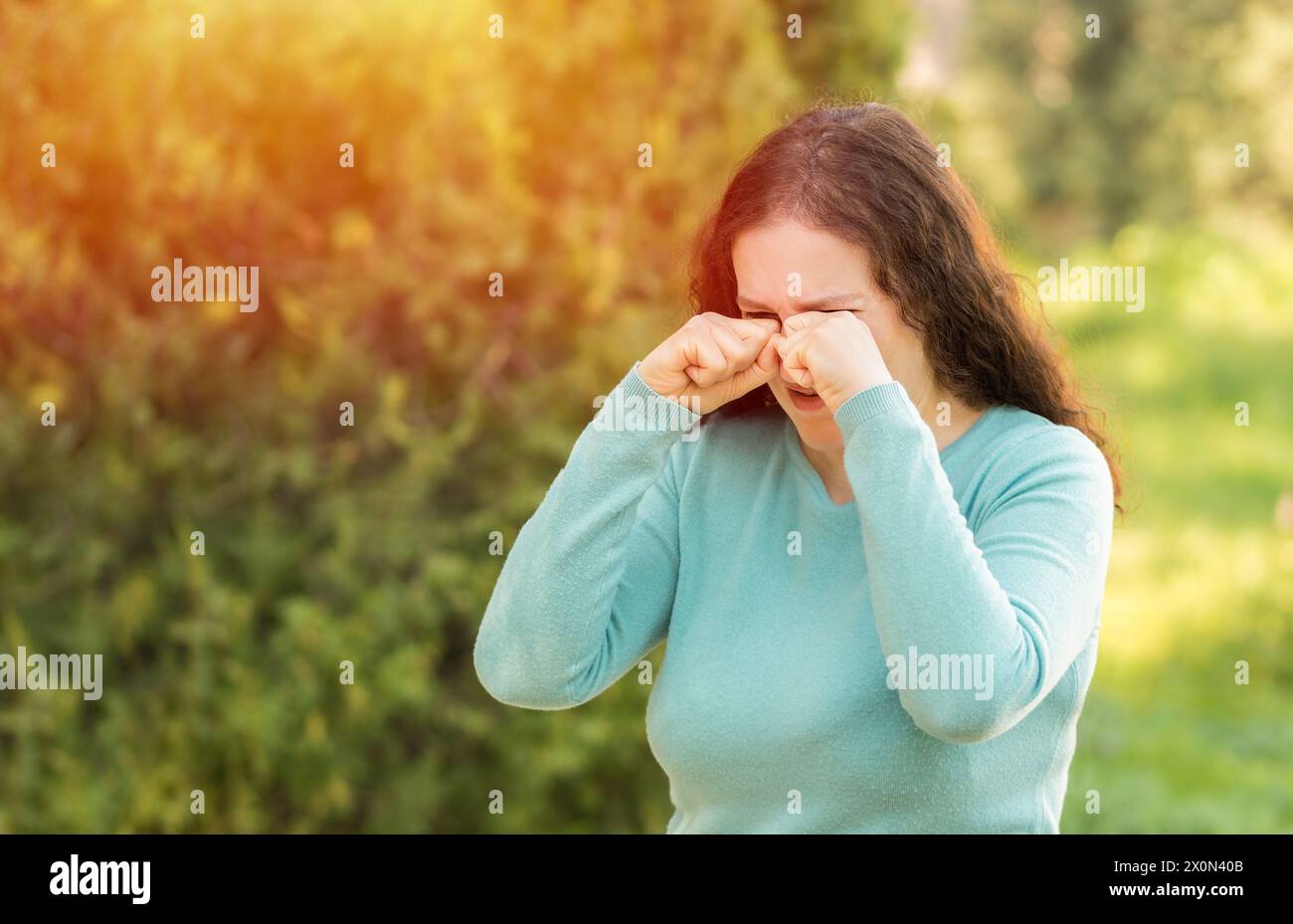 Woman covering eyes by hand of bright sunlight Stock Photo - Alamy