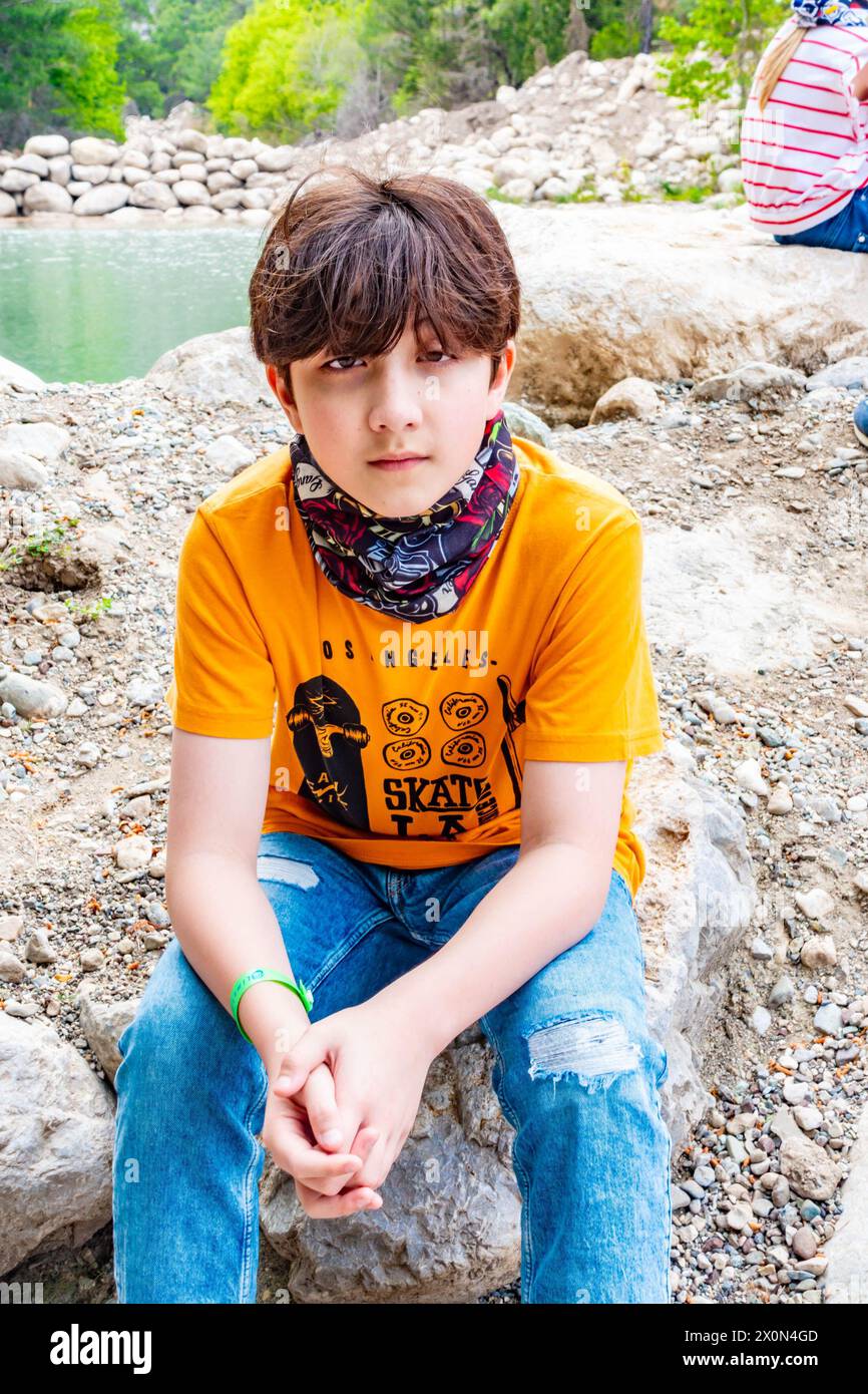 Portrait of an 11 year old boy sat on a rock in The Goynuk Canyon near ...