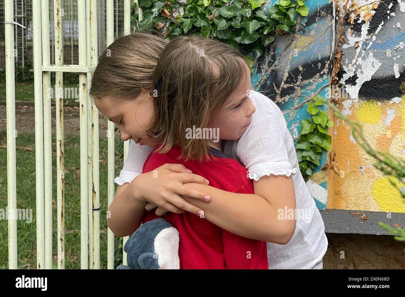 Little girls friends support each other, hug and help to survive ...