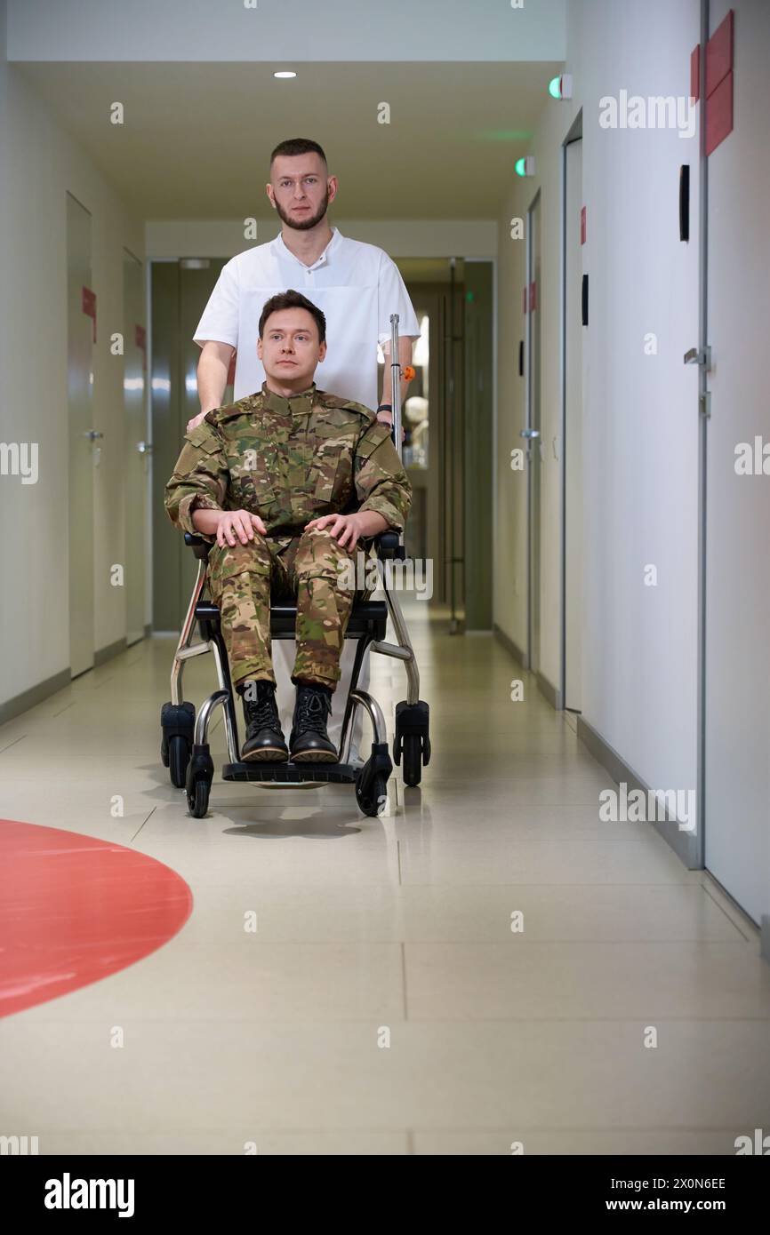 Healthcare worker transporting military patient with disability in ...