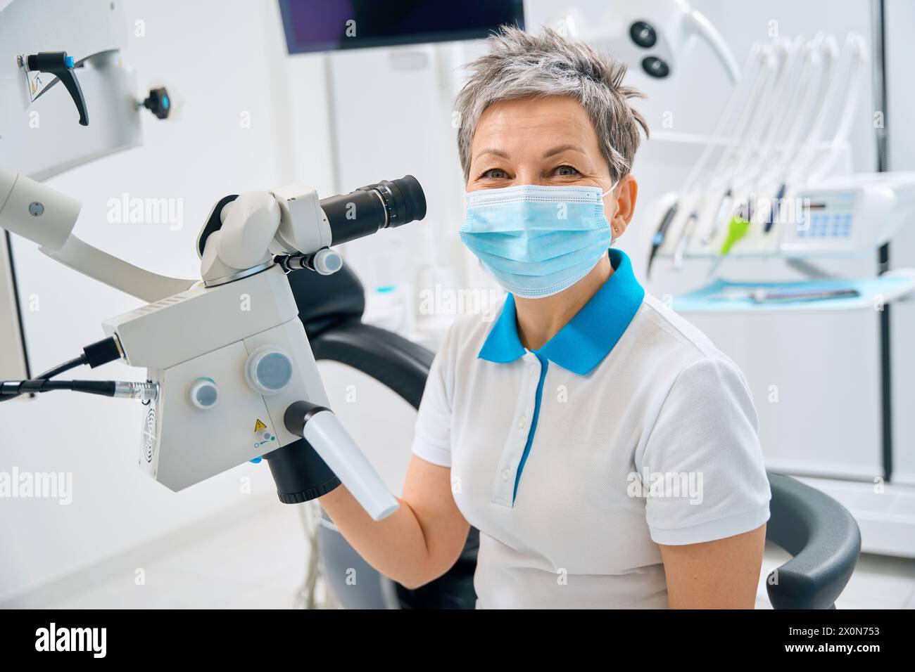 Dental therapist using microscope to fill the tooth canals Stock Photo ...
