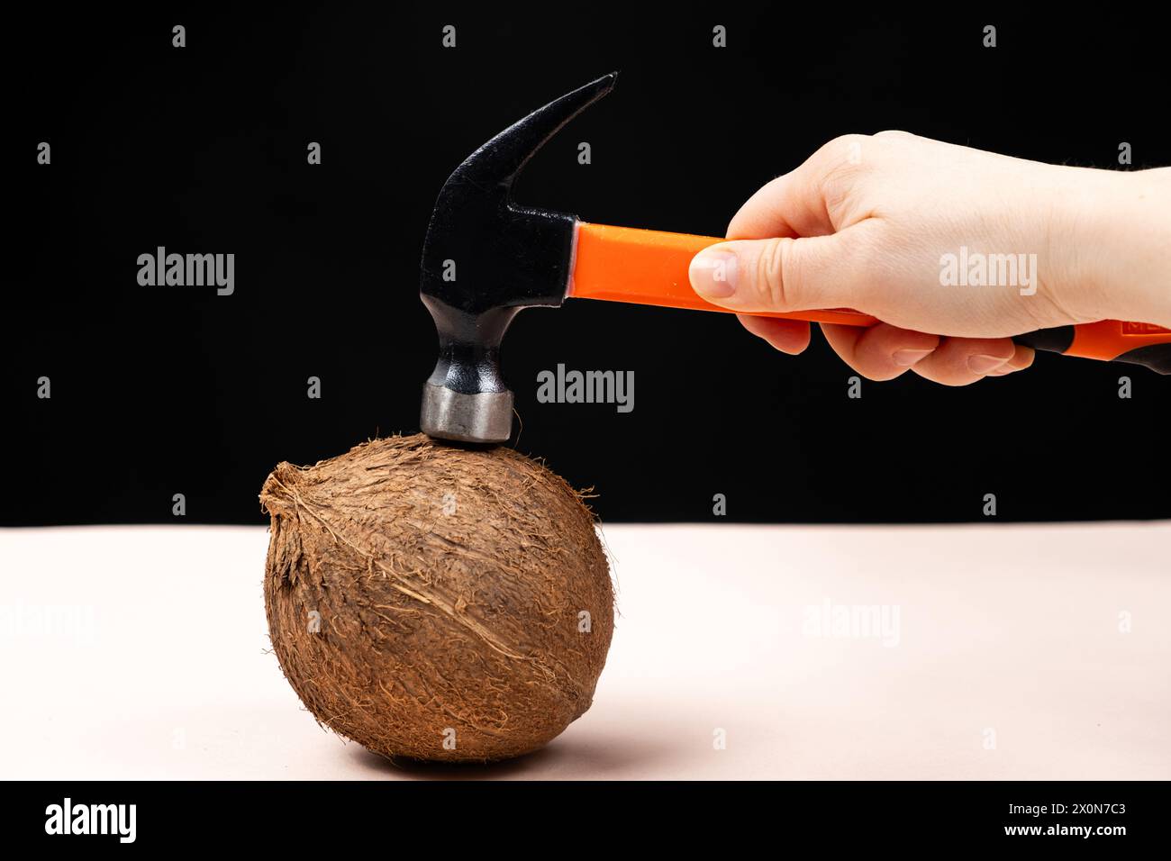 The process of breaking a coconut with a hammer. Ways to open a coconut ...