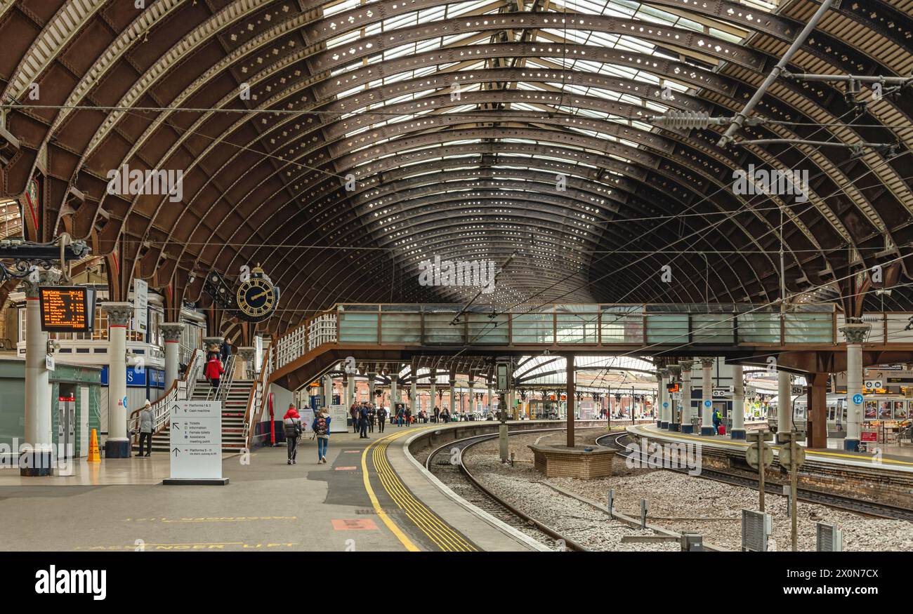 A railway station platform, lined by columns, curves into the distance ...