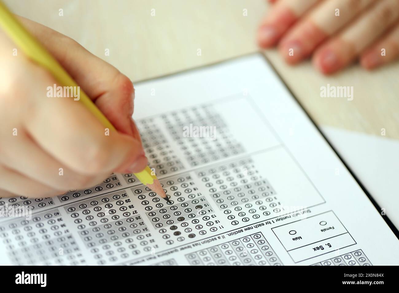 Female student hands testing in exercise and taking fill in exam paper ...