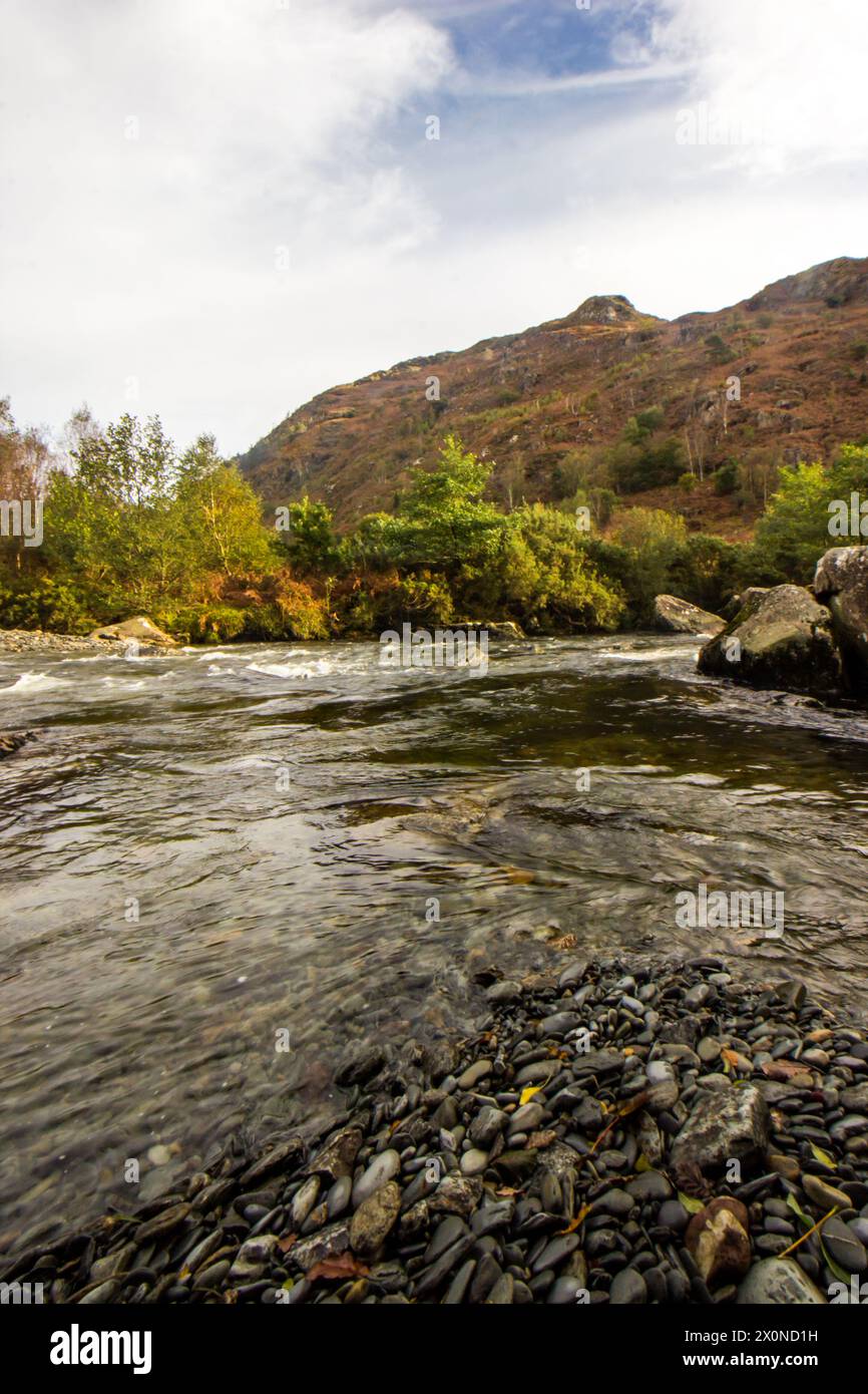 Mountain peak rising over the fast-flowing Aflon Glaslyn in the Eryri ...