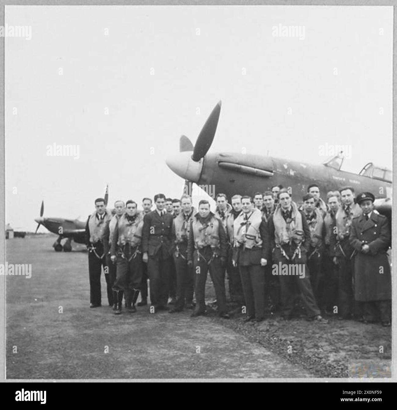 Pilots of the RAF Burma Squadron are shown grouped in front of the ...