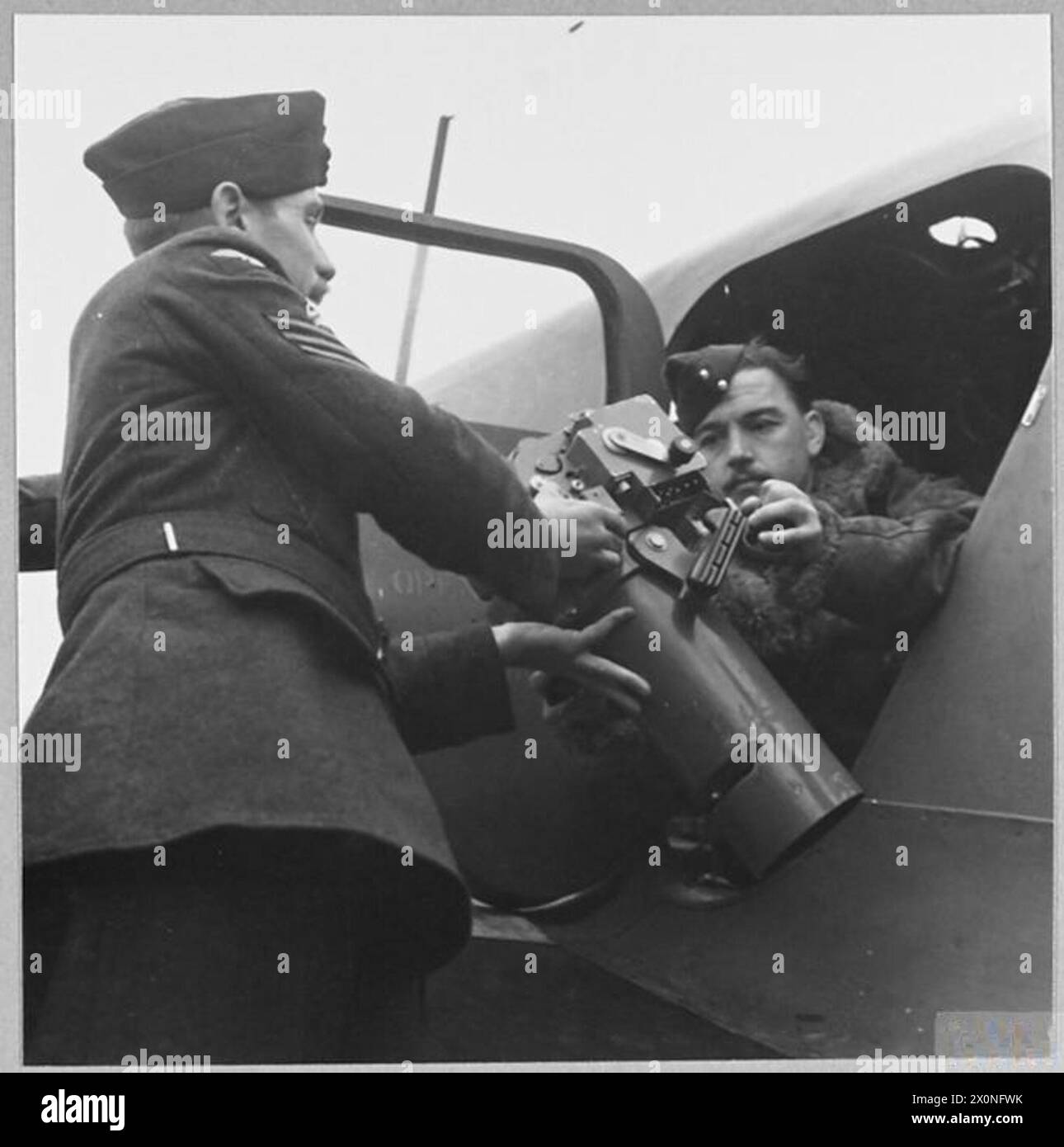 RAF flight sergeant in charge of a photographic section handing over a ...