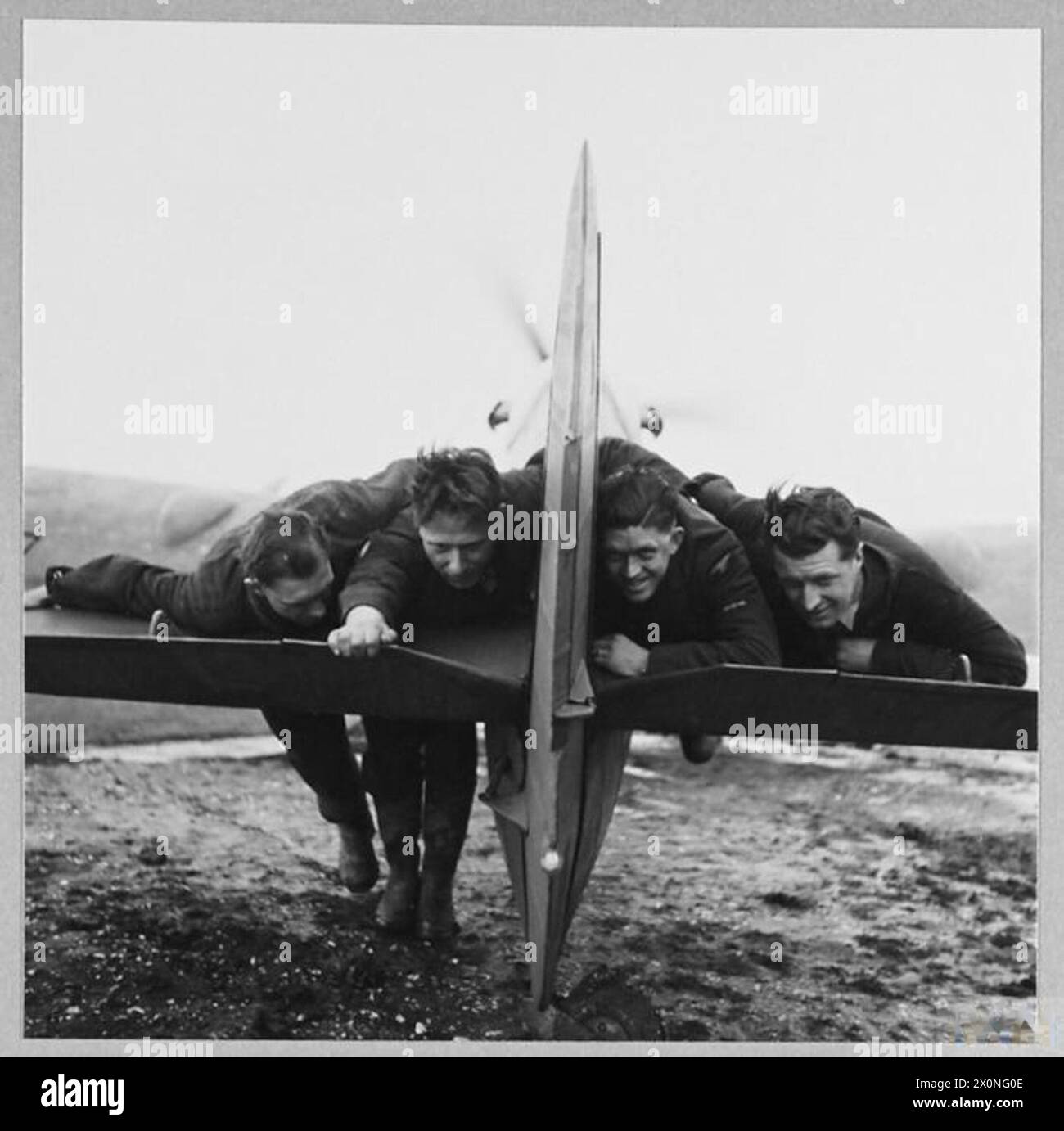 RAF Erks are pictured holding the tail of a Spitfire aircraft while its ...