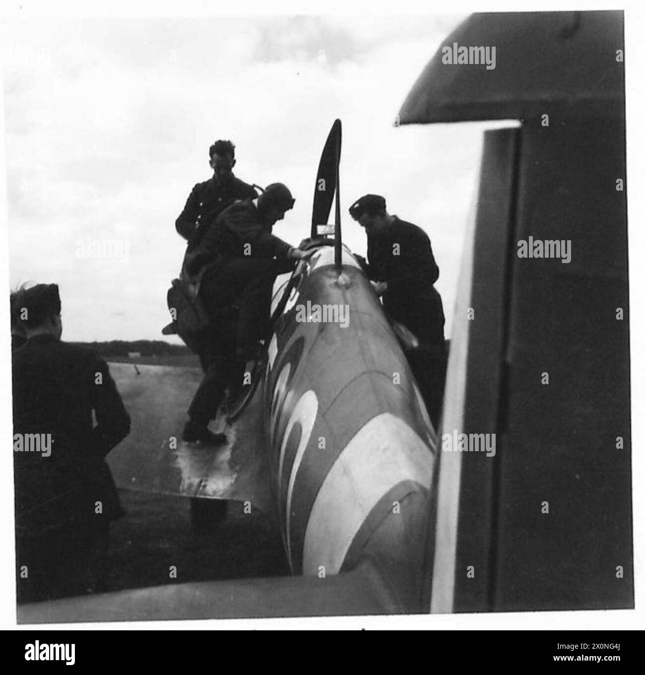 WITH THE R.A.F. IN SCOTLAND - A Spitfire pilot climbs into his machine ...