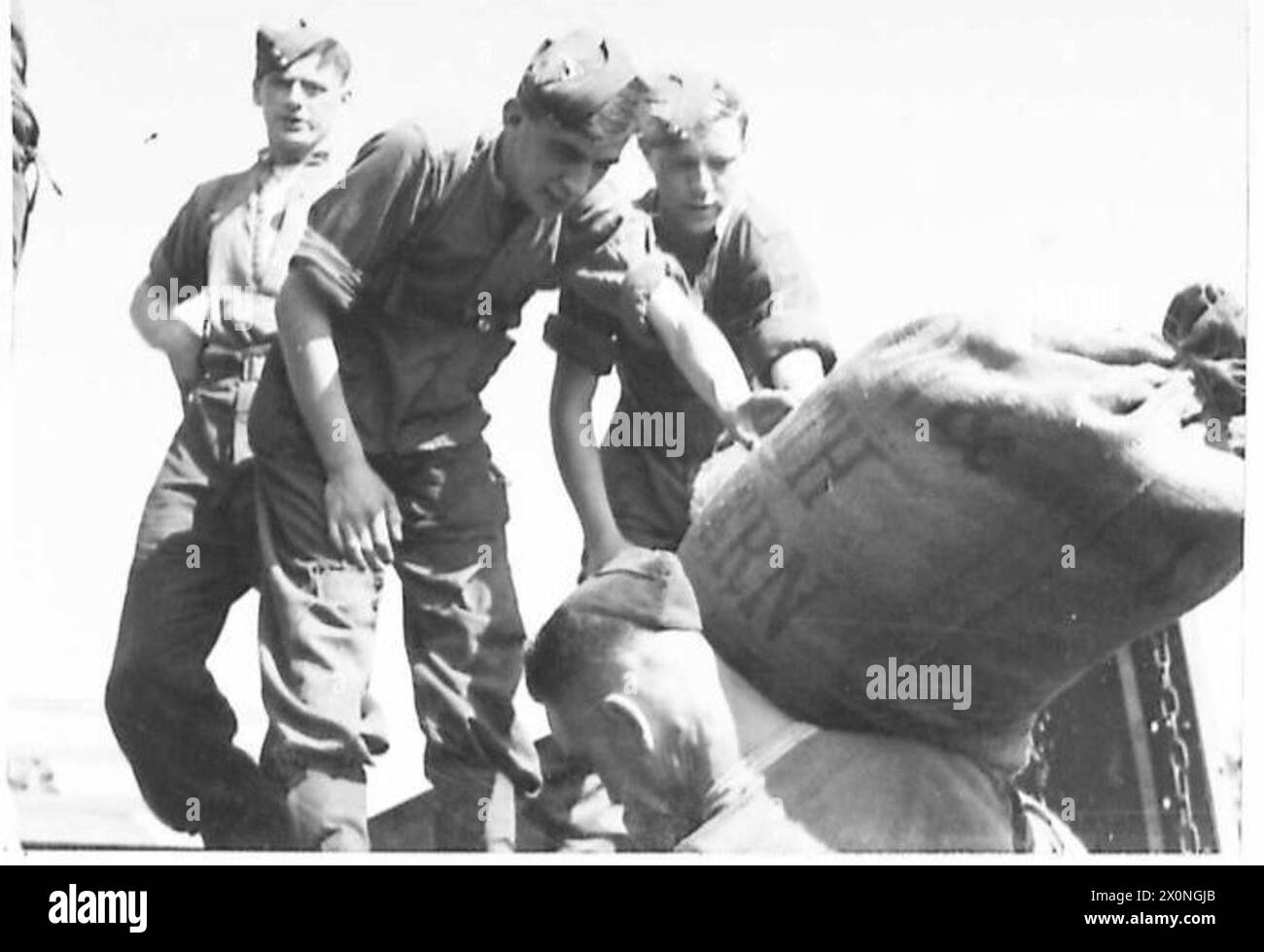 SOLDIERS GATHER IN THE HARVEST - Soldiers loading sacks of grain on to ...