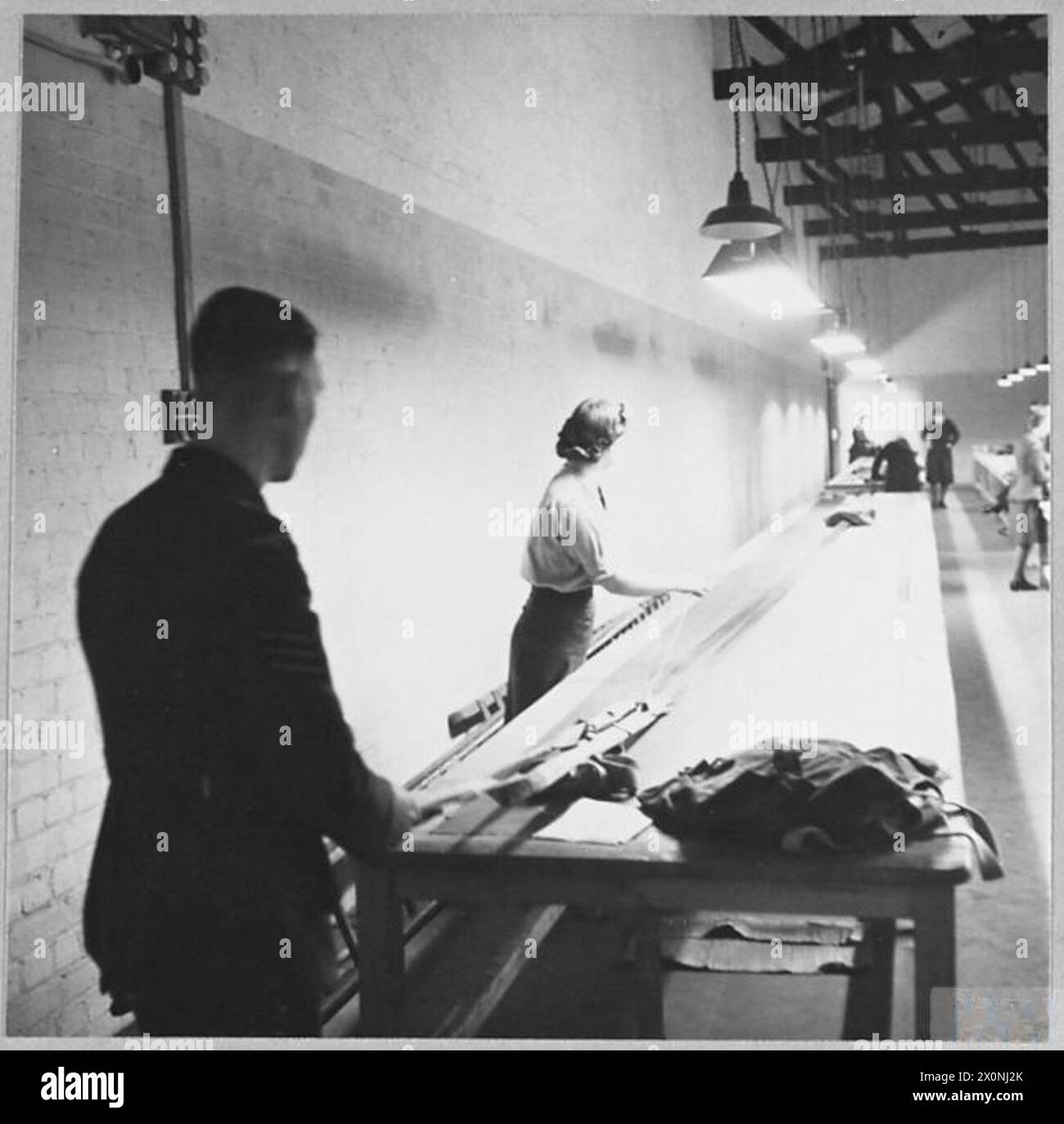 WAAF parachute packers fold and inspect parachute harnesses, checking ...