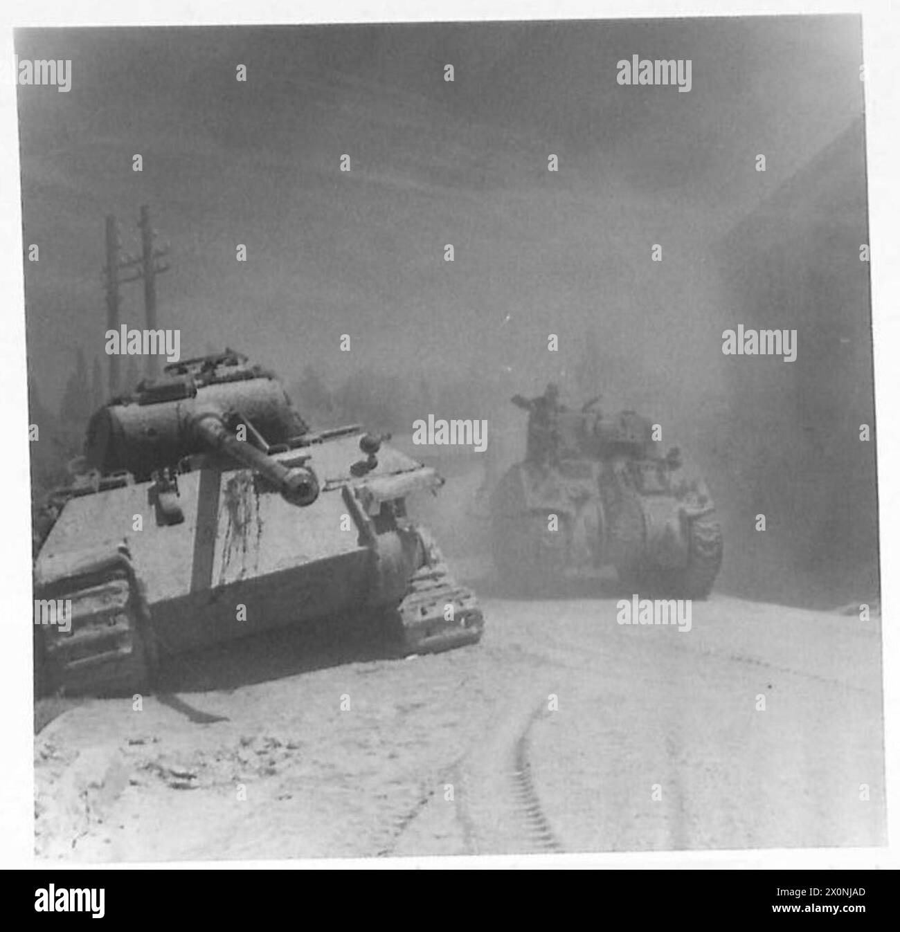 A Sherman tank drives past a destroyed Panther tank during Eighth Army ...