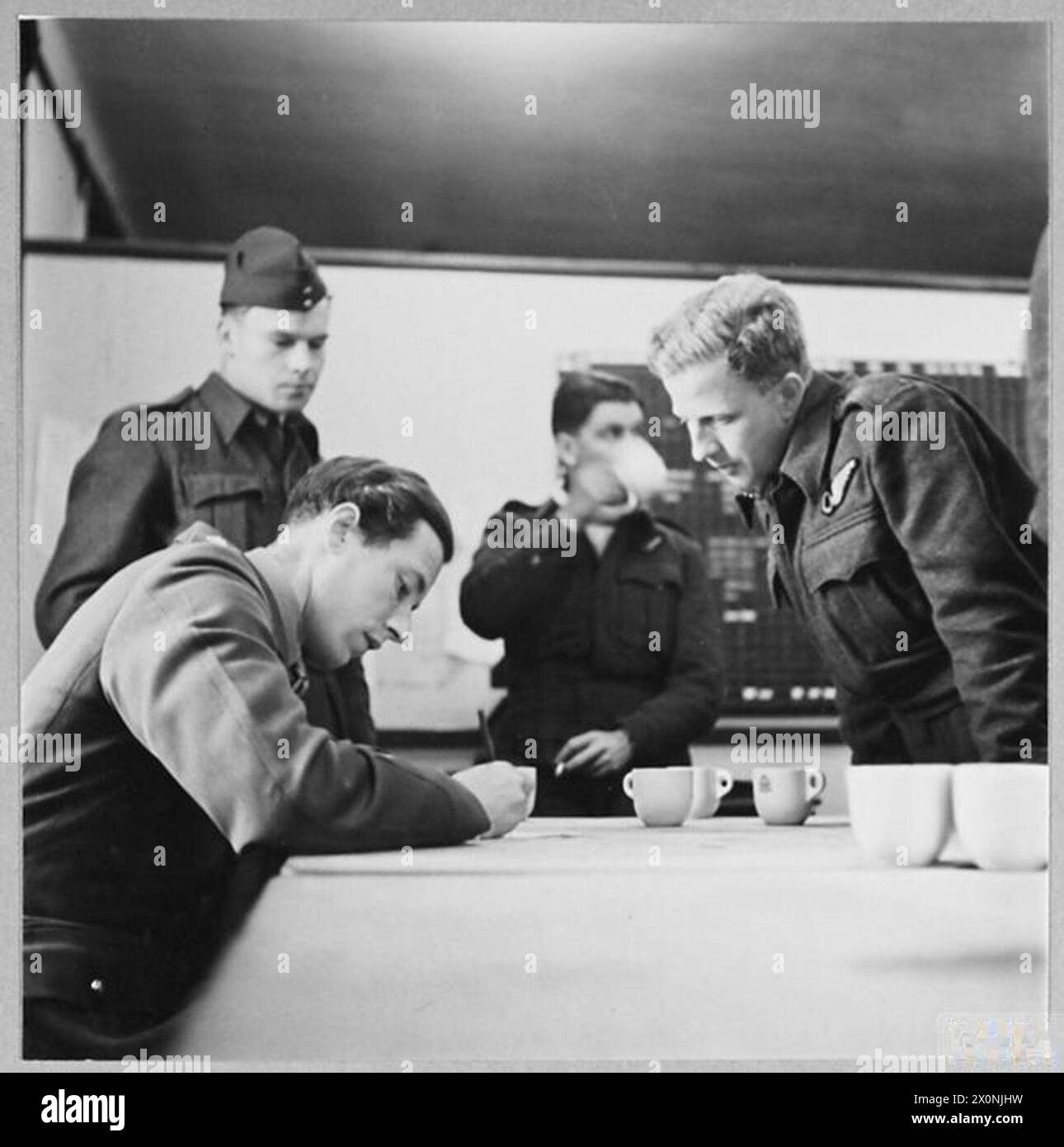Photographic negative showing RAF personnel at a station writing ...
