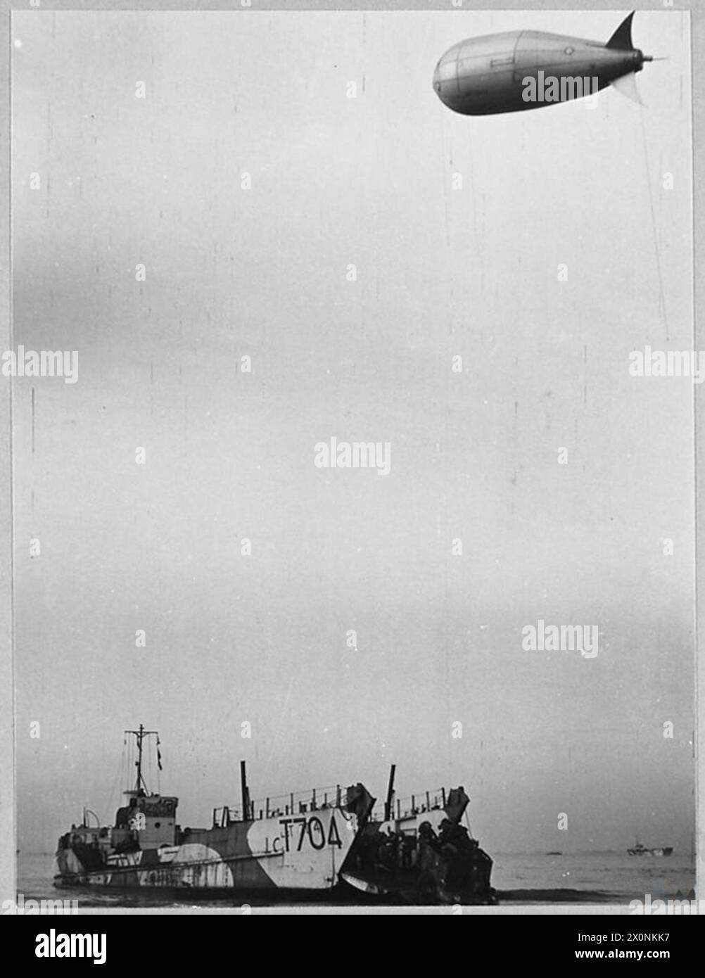 An RAF invasion balloon is launched from a boat toward the beaches ...