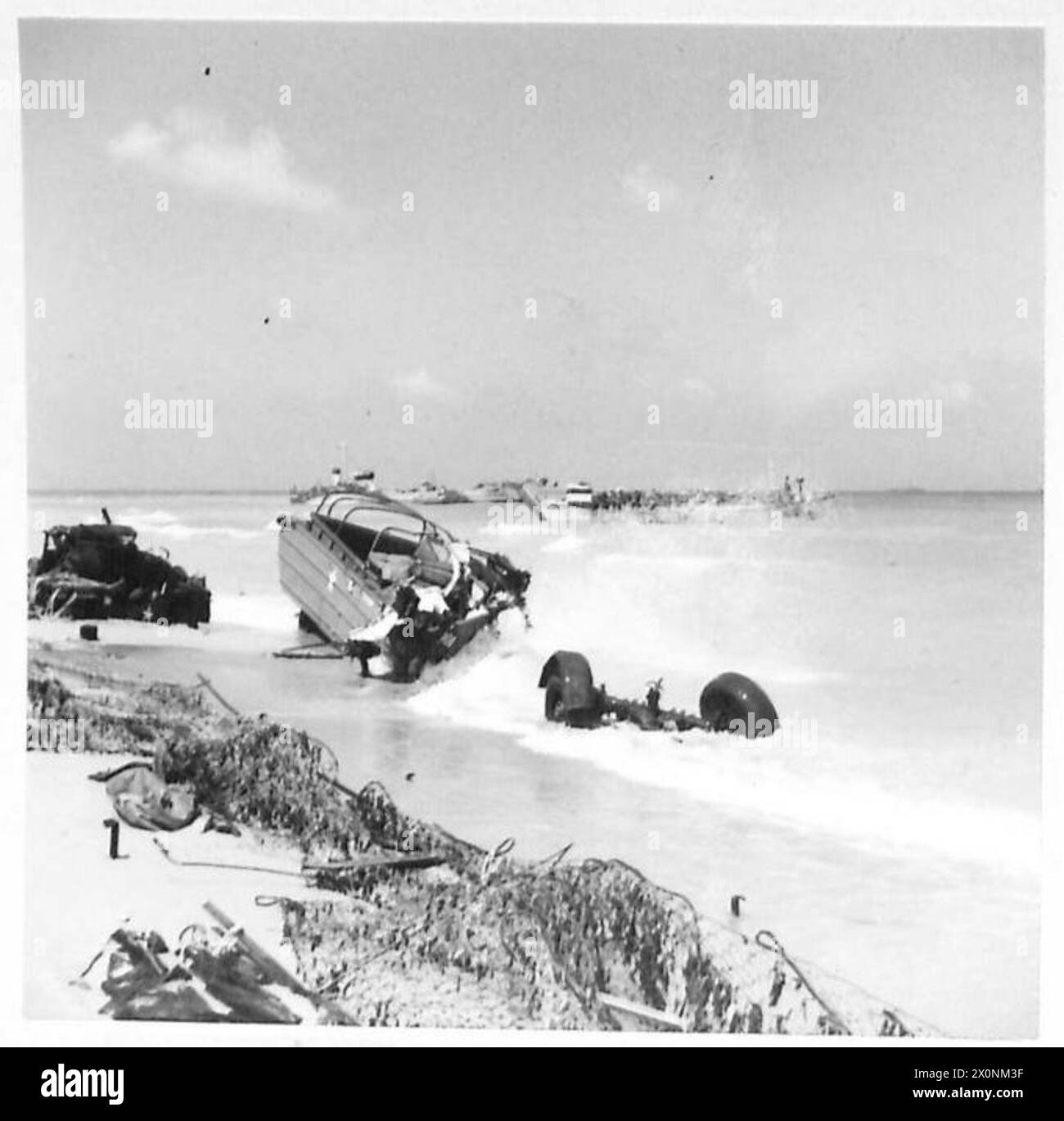 A damaged DUKW amphibious vehicle and jeep on Queen Beach in the Sword ...