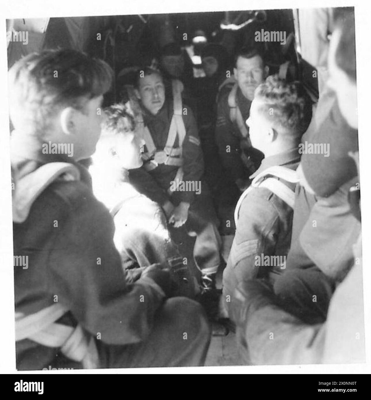 Parachute troops are grouped around the jump hatch inside a Wellington ...