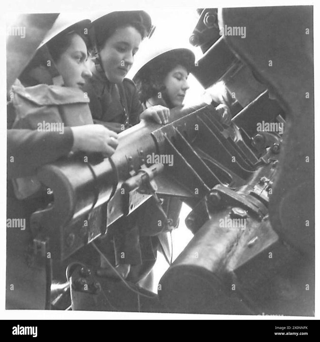 A.T.S. GIRLS SEE HOW THE GUNS WORK - Three of the girls examining the ...