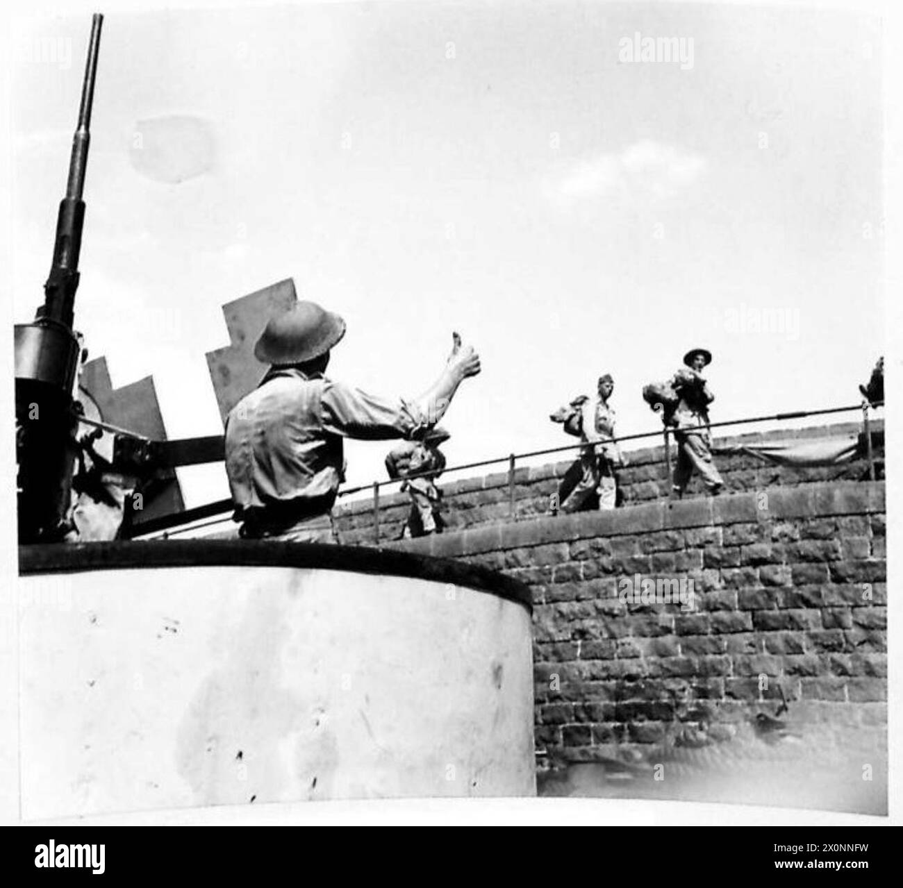 A gunner aboard an LCI signals approval to Canadian troops boarding the ...