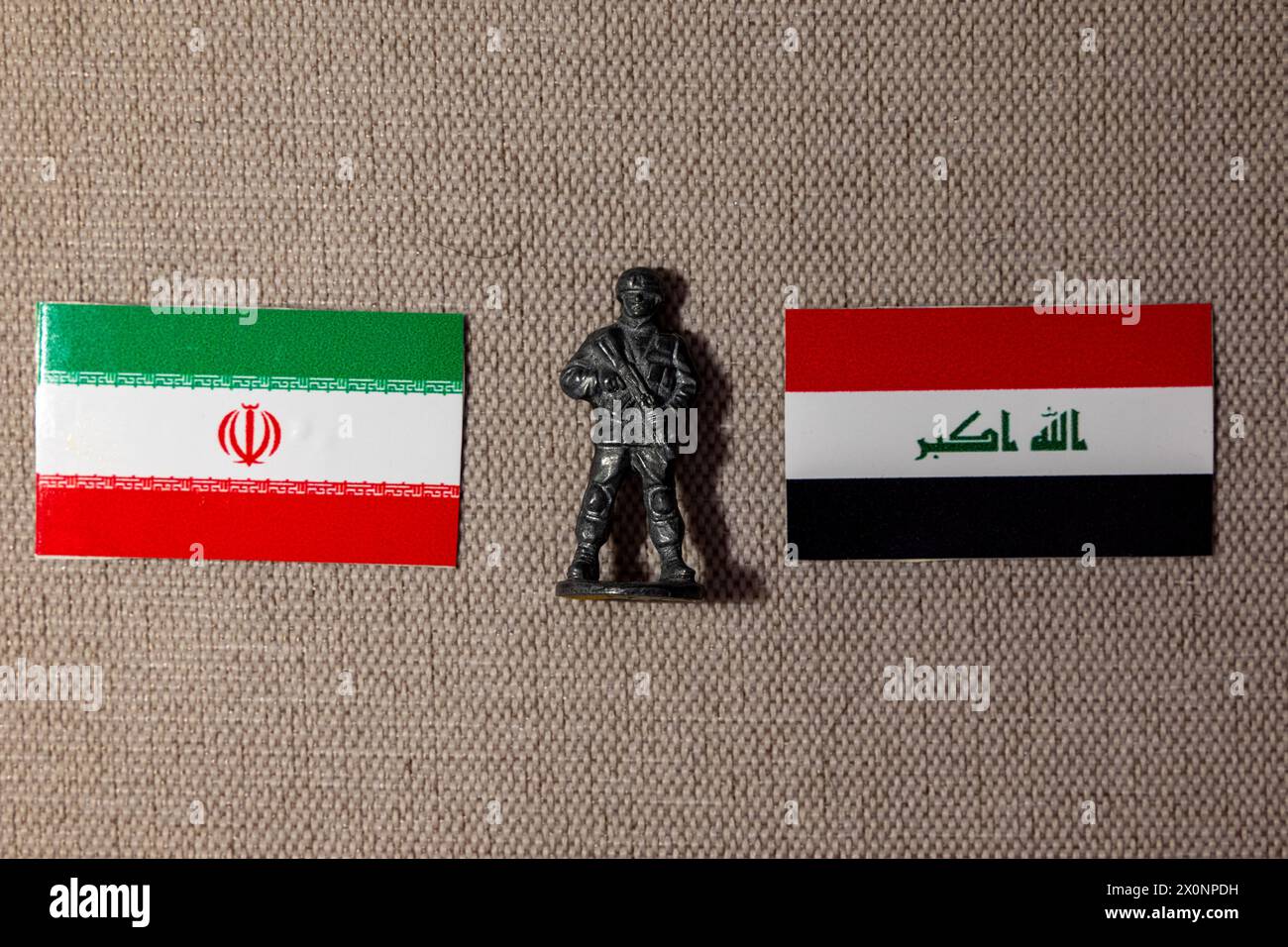 A soldier figurine on the background of the flags of Iran and Iraq ...