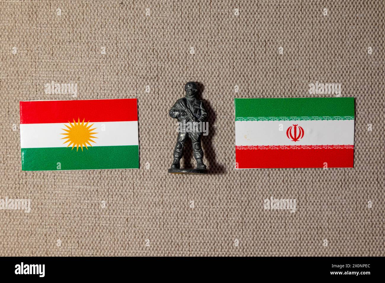A soldier figurine on the background of the flags of Iran and Kurdistan ...