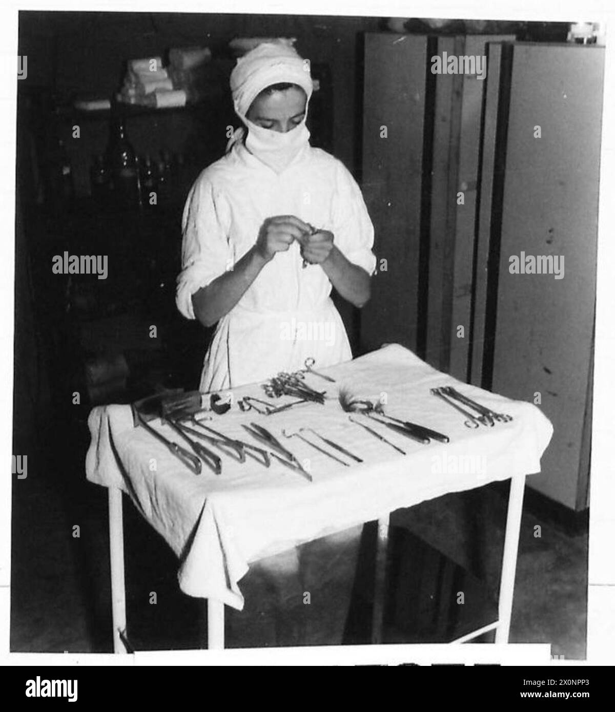 Sister M. Willis prepares a surgical needle in an operating theatre for ...