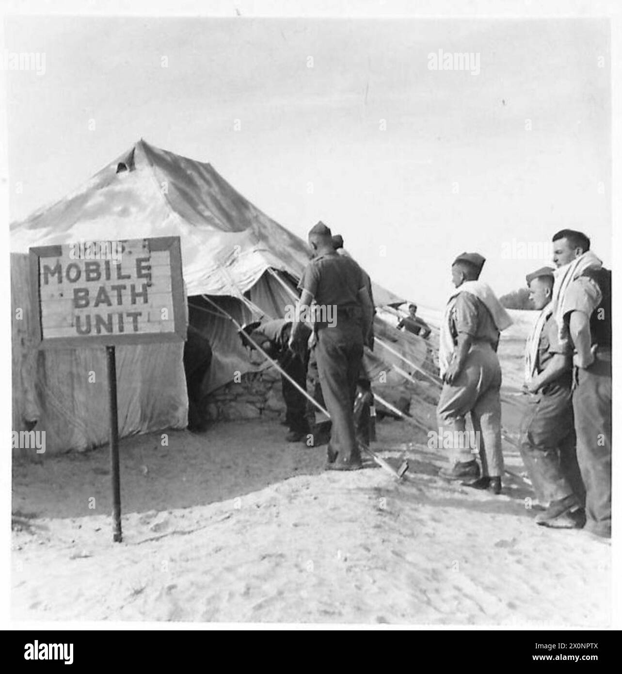 HOT BATHS FOR TROOPS IN THE WESTERN DESERT - British troops entering the Mobile Bath Unit ...