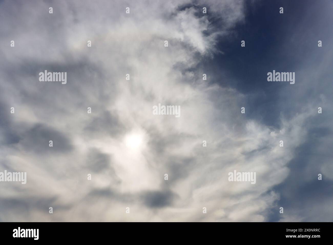 Gray, cloudy sky with hidden sun. The sun shines through the clouds ...