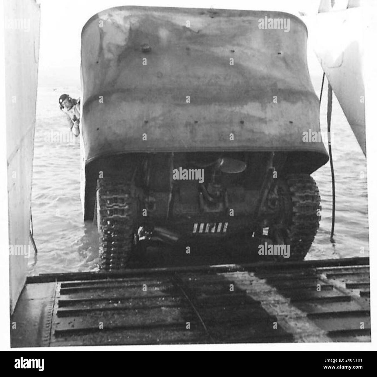 Amphibious tanks leave the ramp of an L.C.T. and enter the sea during ...