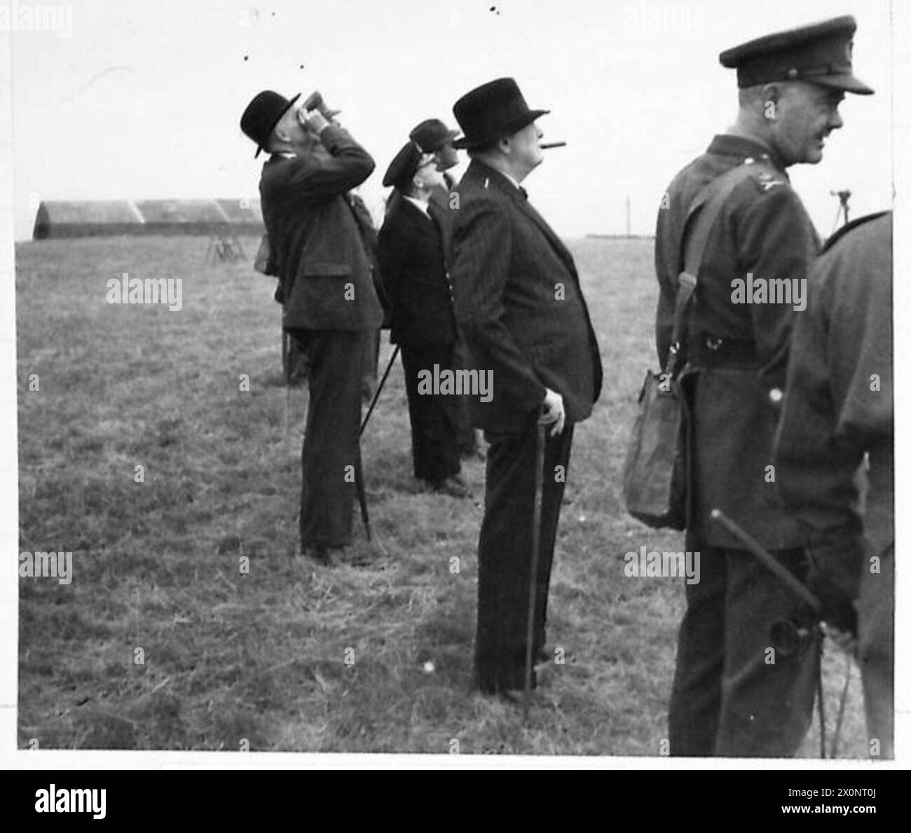 Prime Minister Winston Churchill observes a demonstration of a secret ...