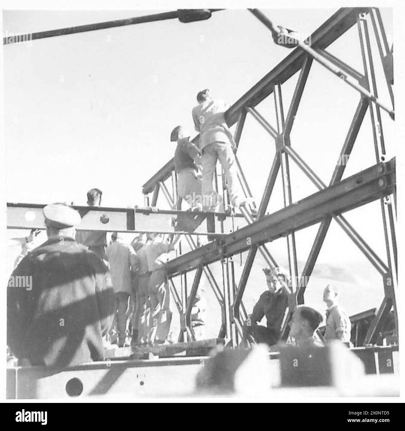 Panel pins are driven to assemble and secure a Bailey bridge during ...