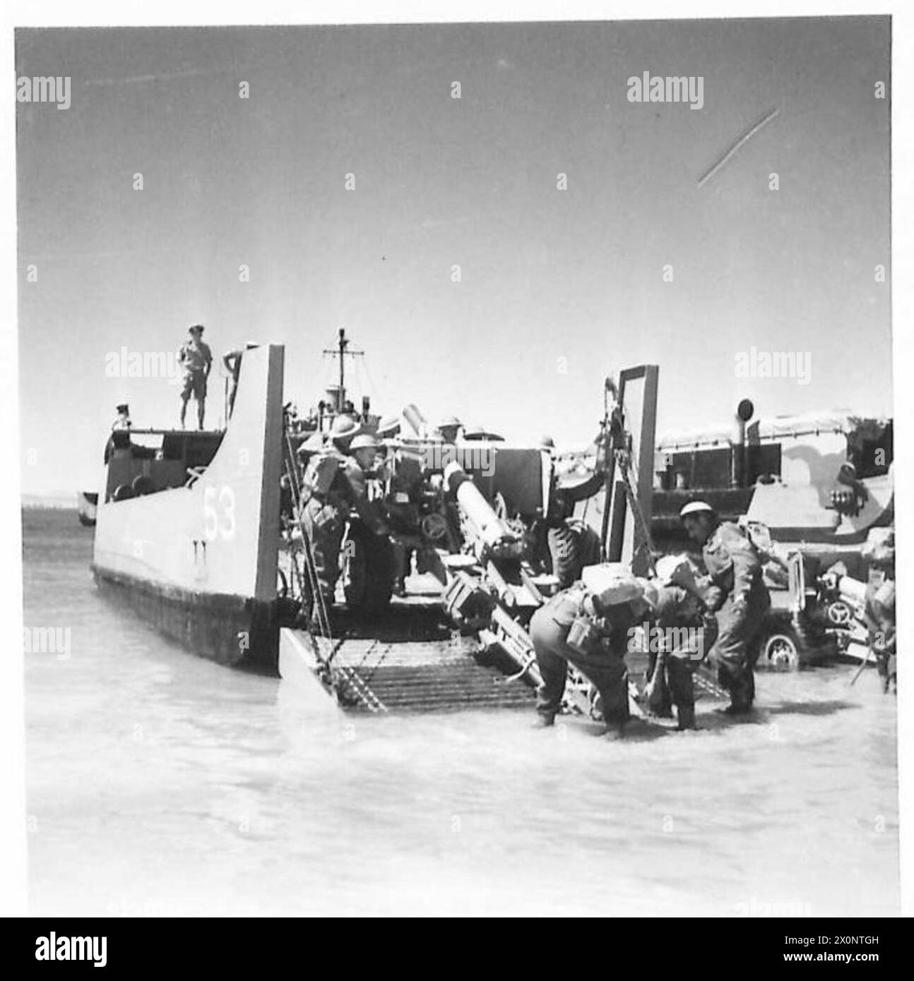 A 25-pounder field gun is being unloaded from a D-type lighter in North ...