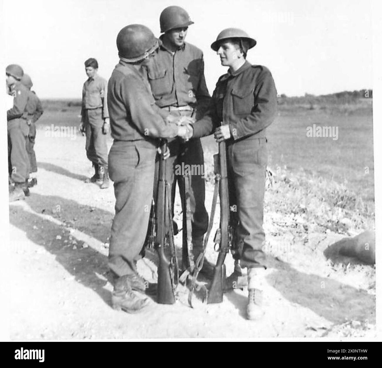 Sgt. L.R. Engstrom and Pvt. L.B. Woodie congratulate Rfn. Savage during ...