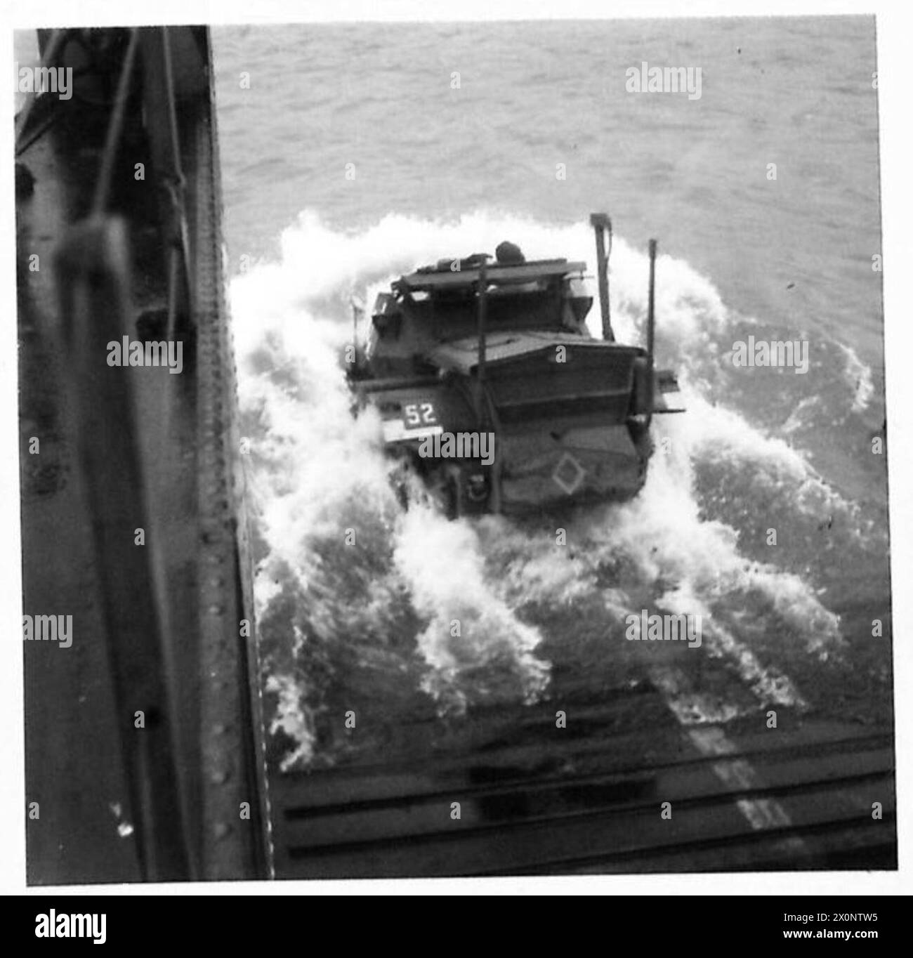 A Ford Lynx scout car is shown leaving the ramp of a Landing Craft Tank ...