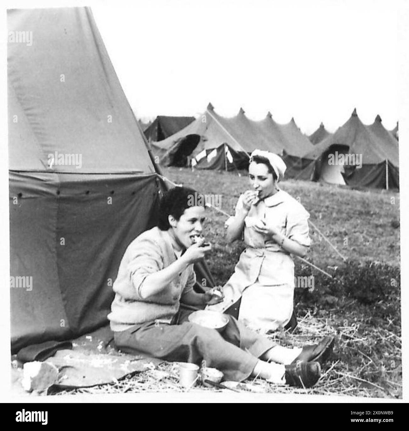 Two French nurses have lunch outside tented quarters while serving in ...
