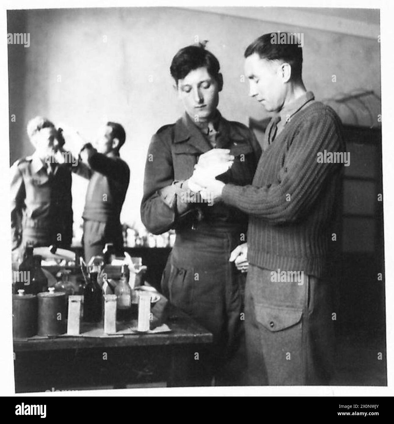 Photograph showing two prisoners of war receiving treatment for hand ...