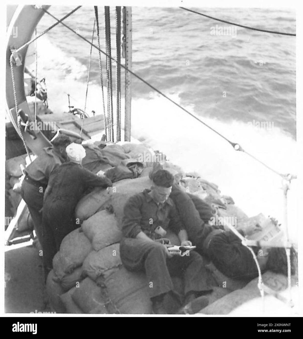 British Army soldiers sit on stored supplies aboard decks in Tobruk ...